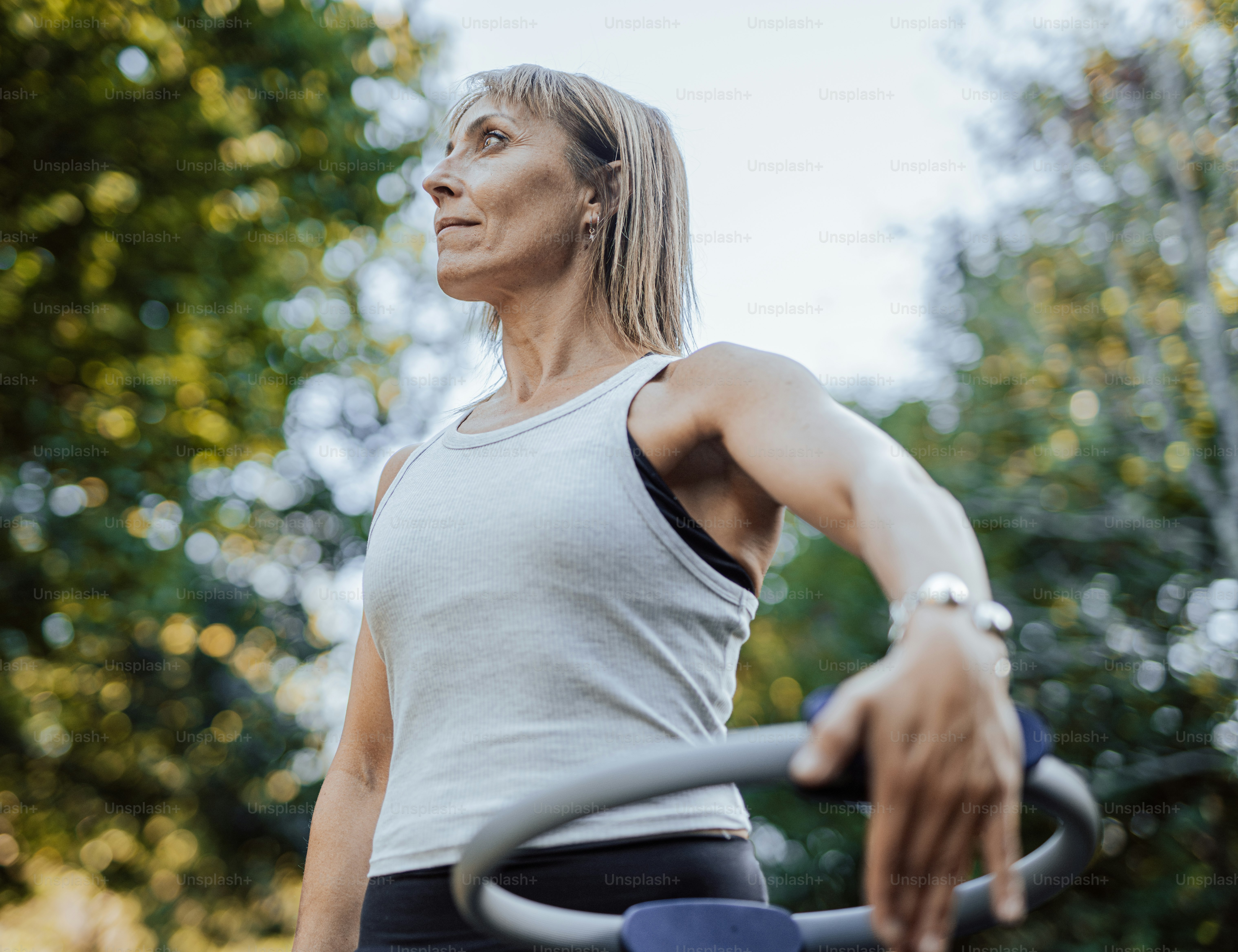 A woman doing exercises on a stationary exercise bike photo – Pilates ...