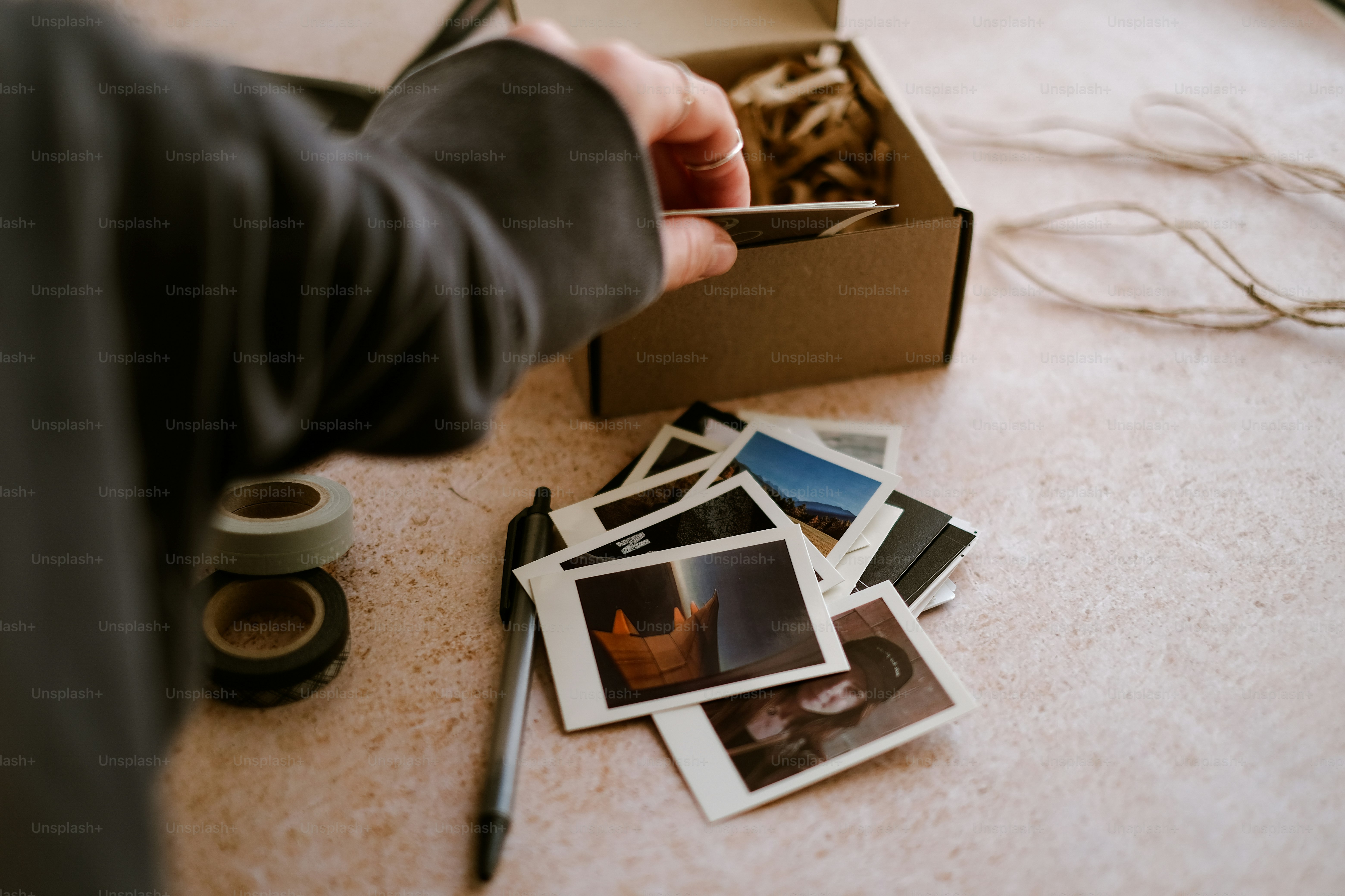 A person holding a card near a box of photos photo – Travel Image on ...