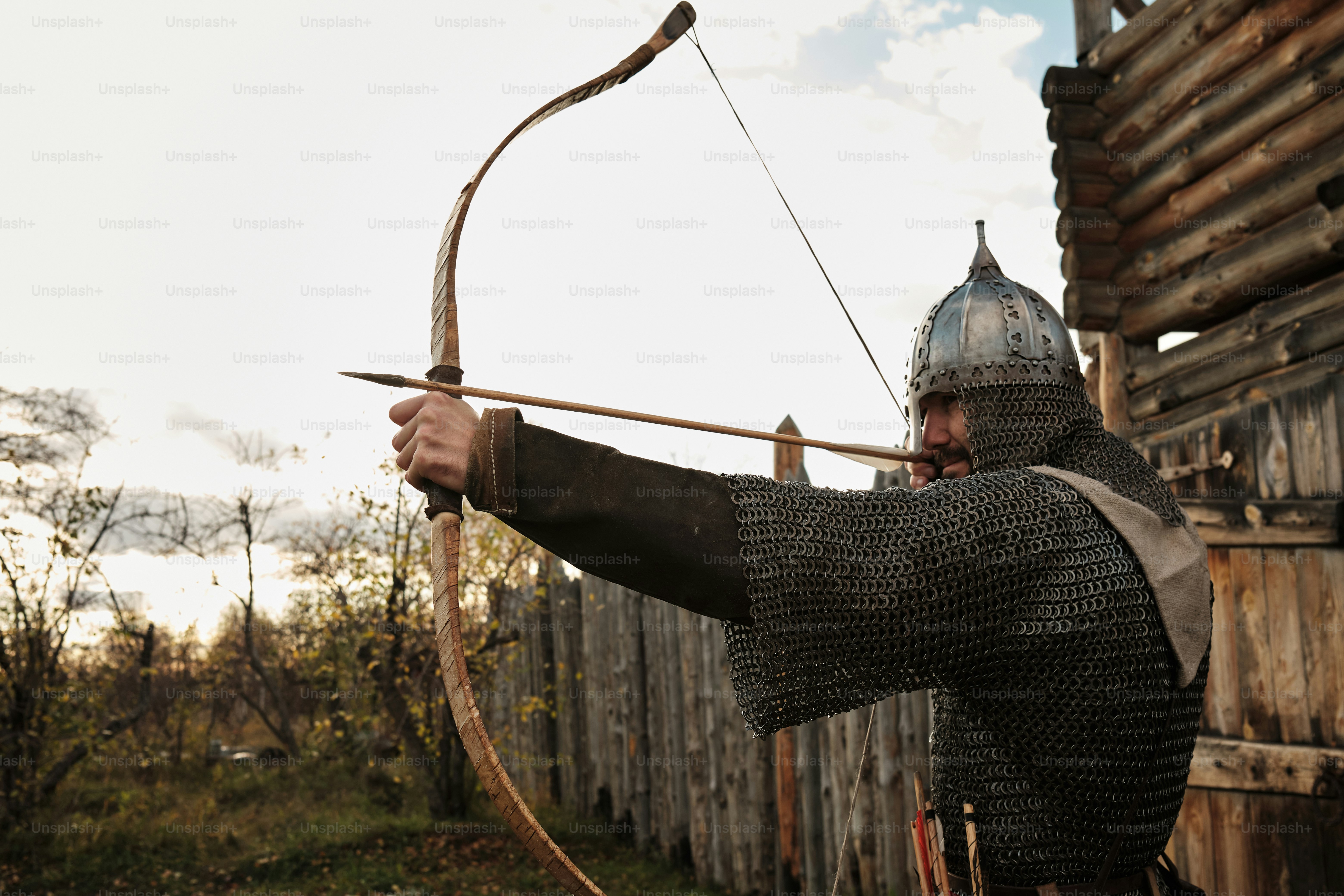 A man dressed in armor holding a bow and arrow photo – Medieval Image ...