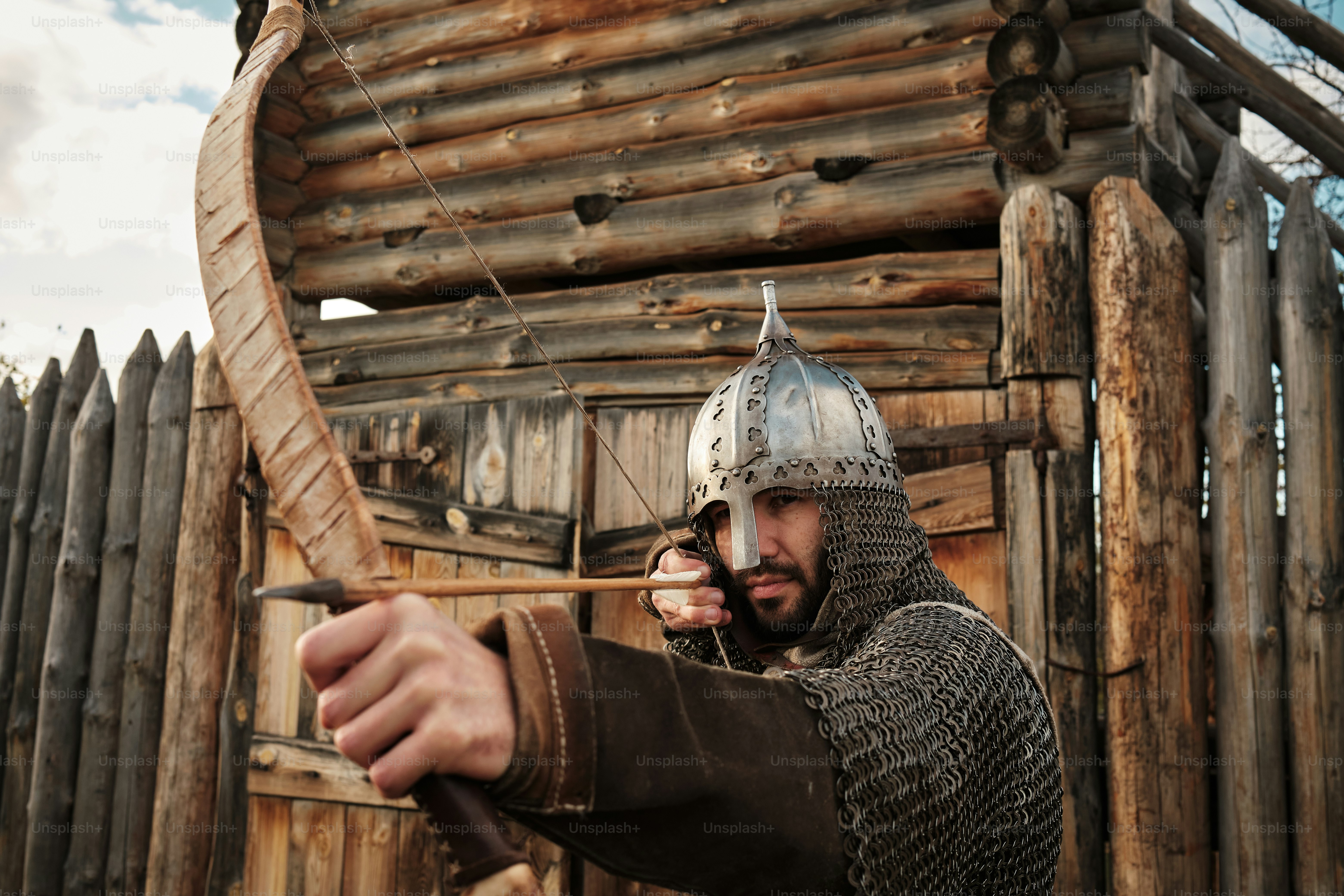 A man in a medieval outfit holding a bow and arrow photo – Knight Image ...