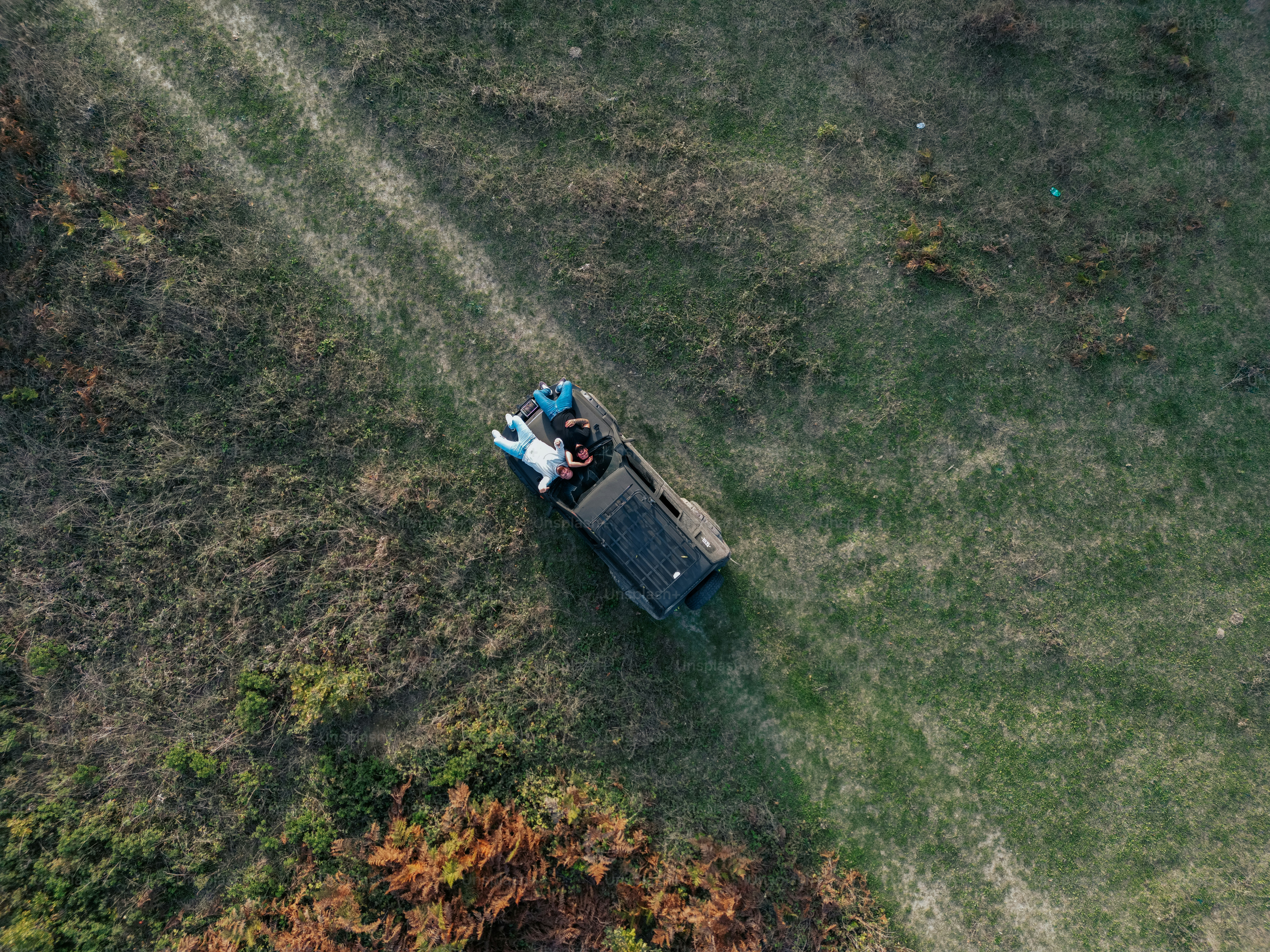 An aerial view of two people sitting on a truck photo – Offroad Image ...