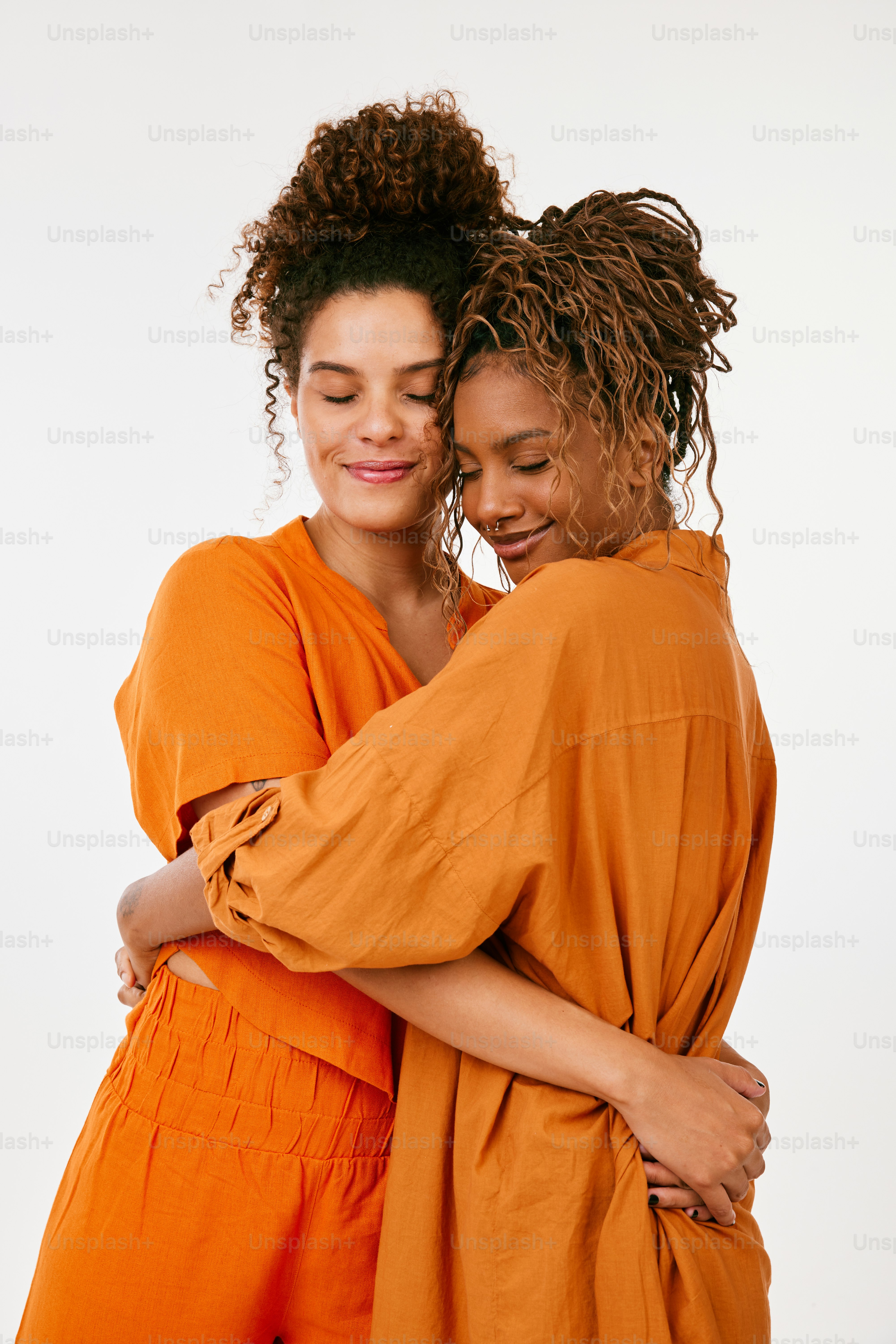 Two women hugging each other in orange outfits photo – Fashion Image on ...