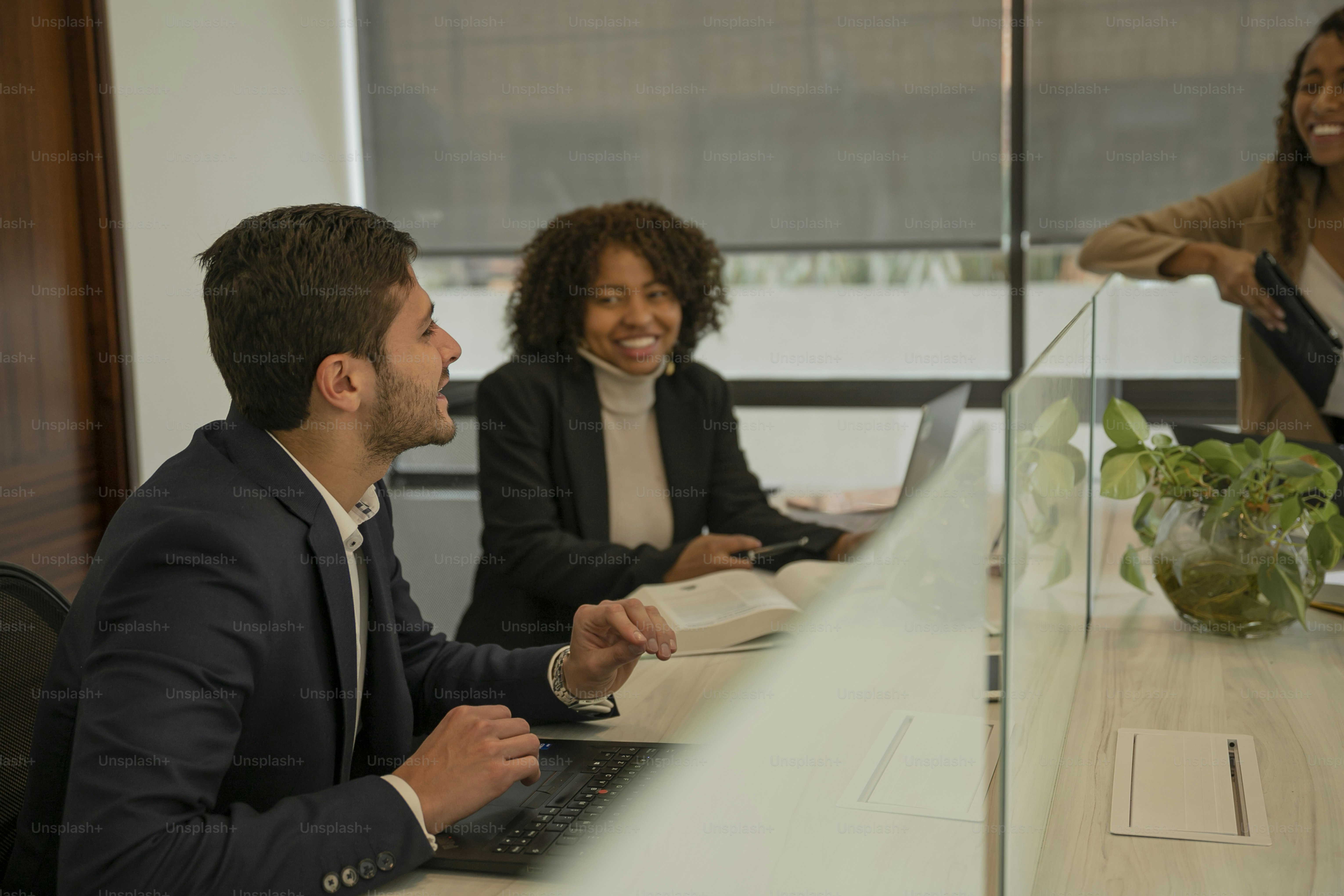 Un groupe de personnes assises autour d’une table avec un ordinateur ...
