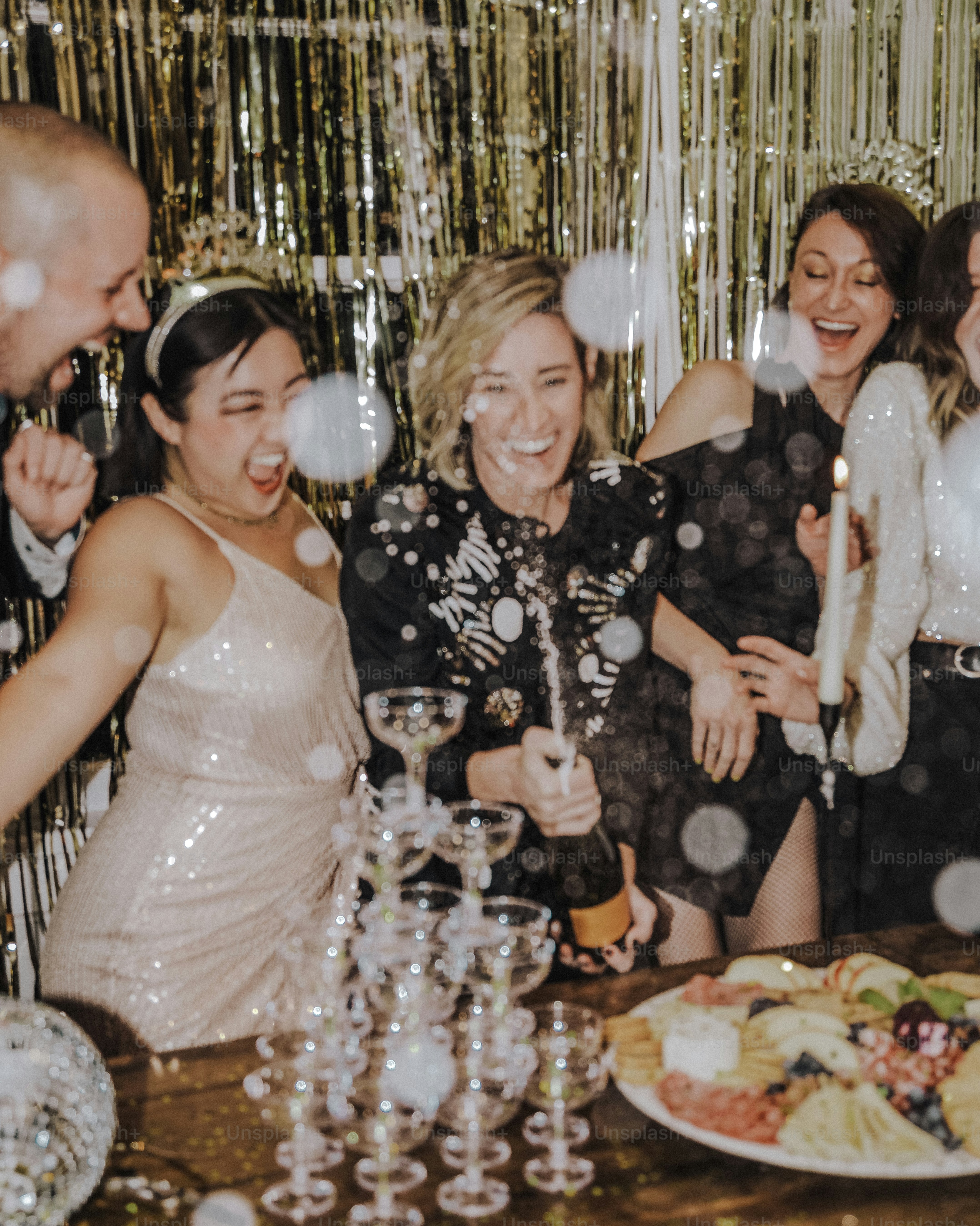 A group of people standing around a table photo – Party Image on Unsplash