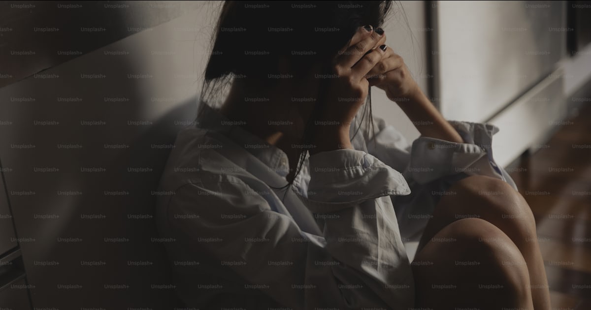 바닥에 앉아 머리에 손을 얹고 있는 여성 사진 Unsplash의 감정적인 이미지