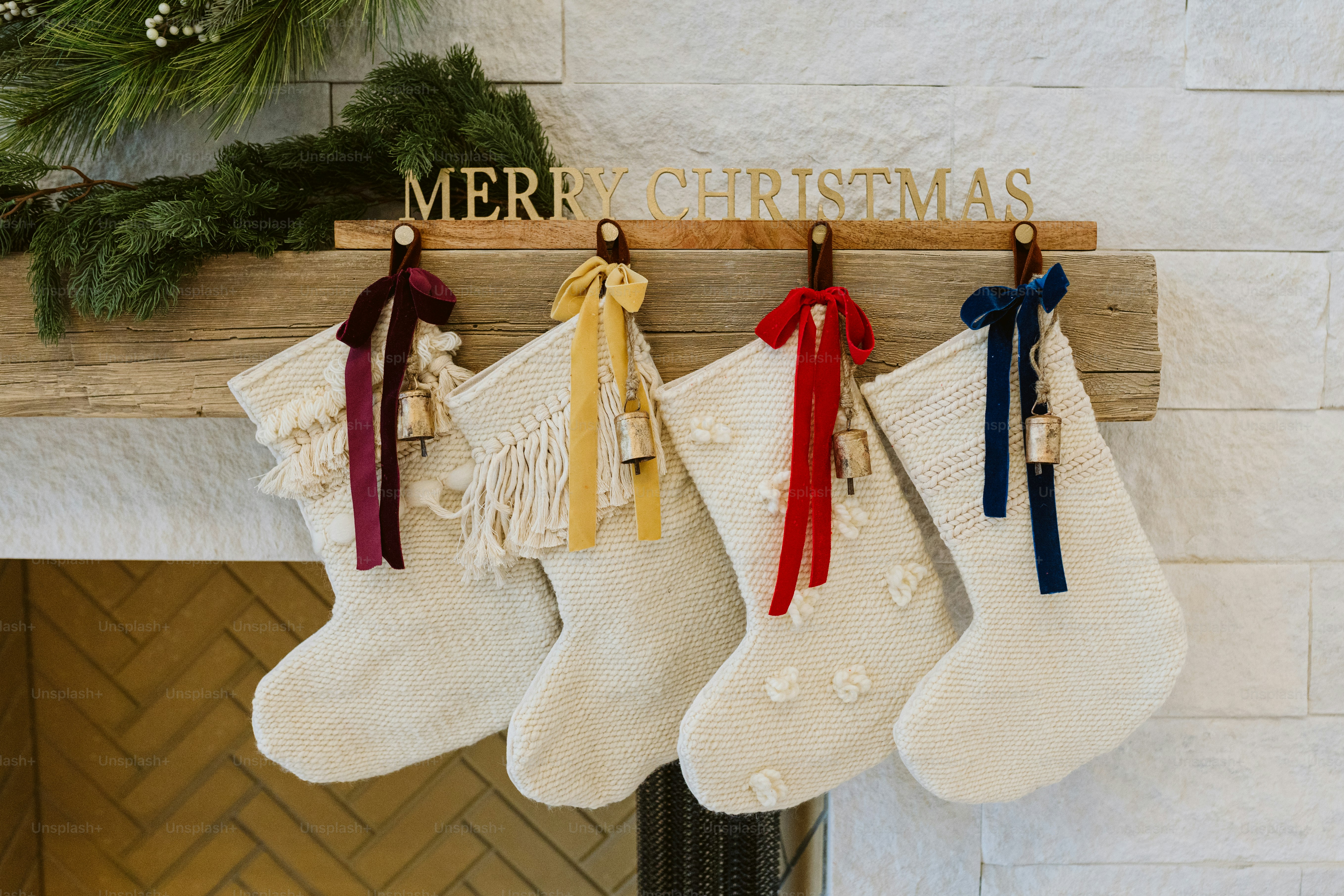 Stockings hanging from a fireplace with a merry christmas sign in the ...