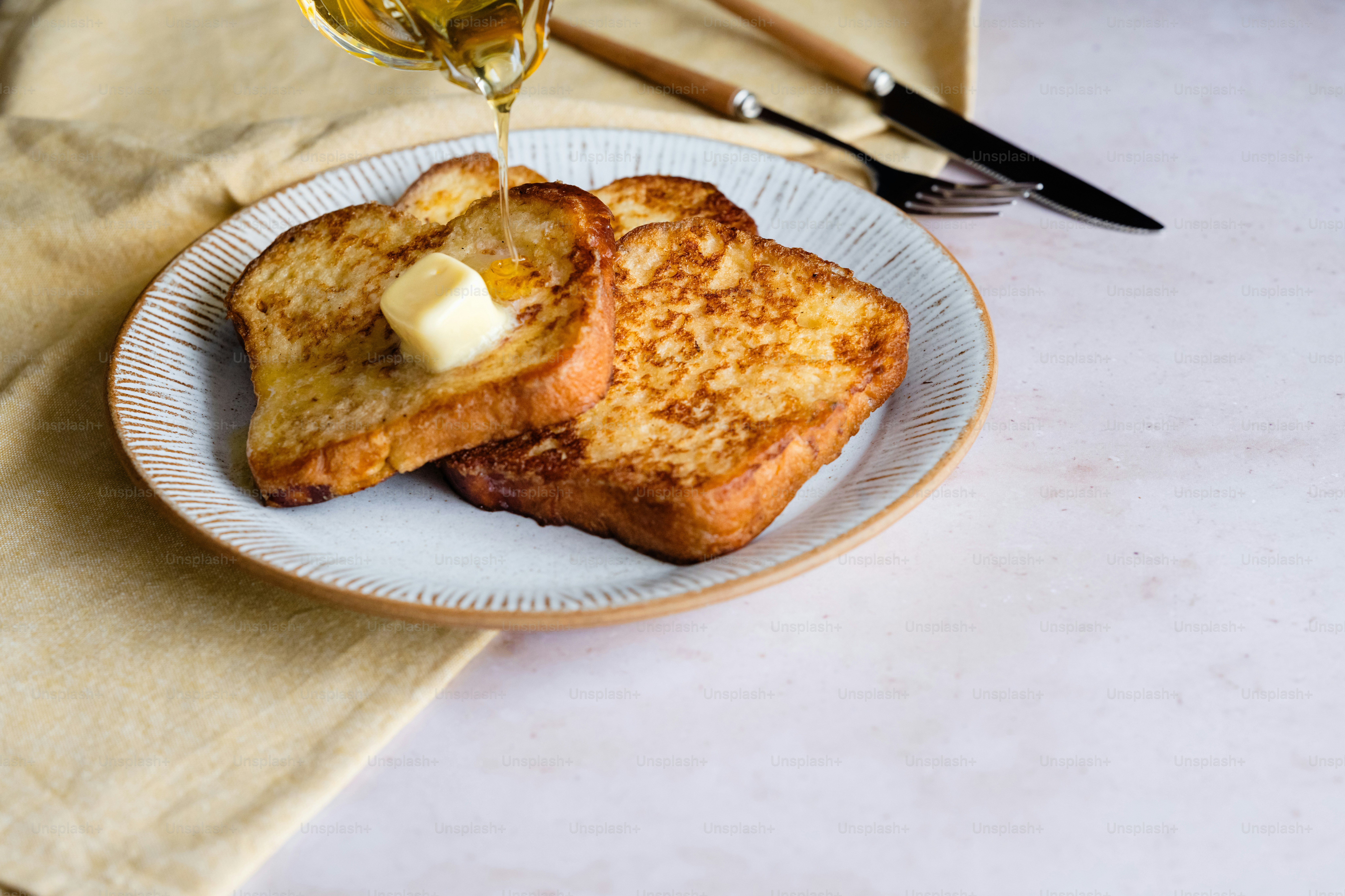 Two pieces of toast on a plate with butter and a glass of wine photo ...