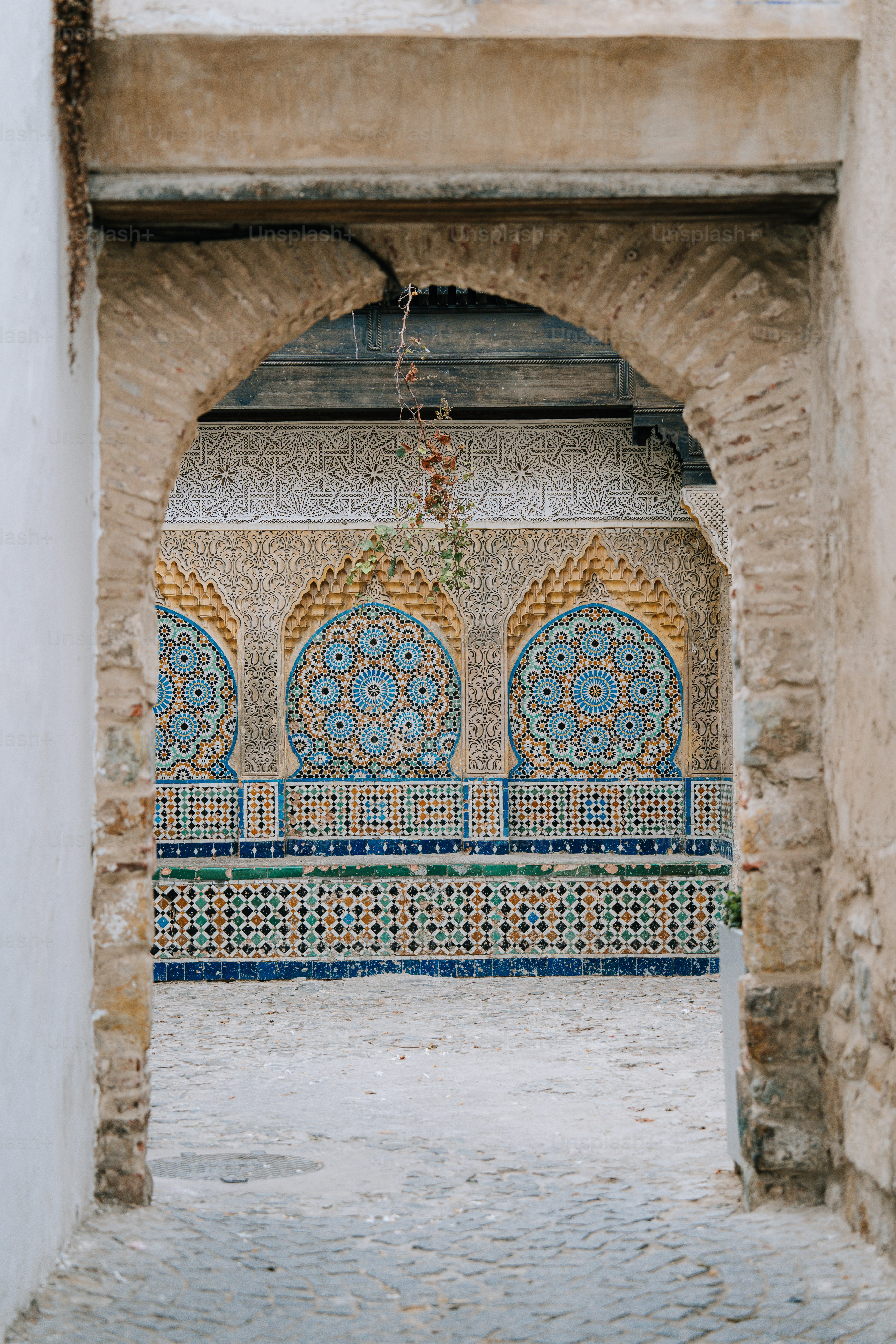 An archway in a building with a decorative tile design photo – Arch ...