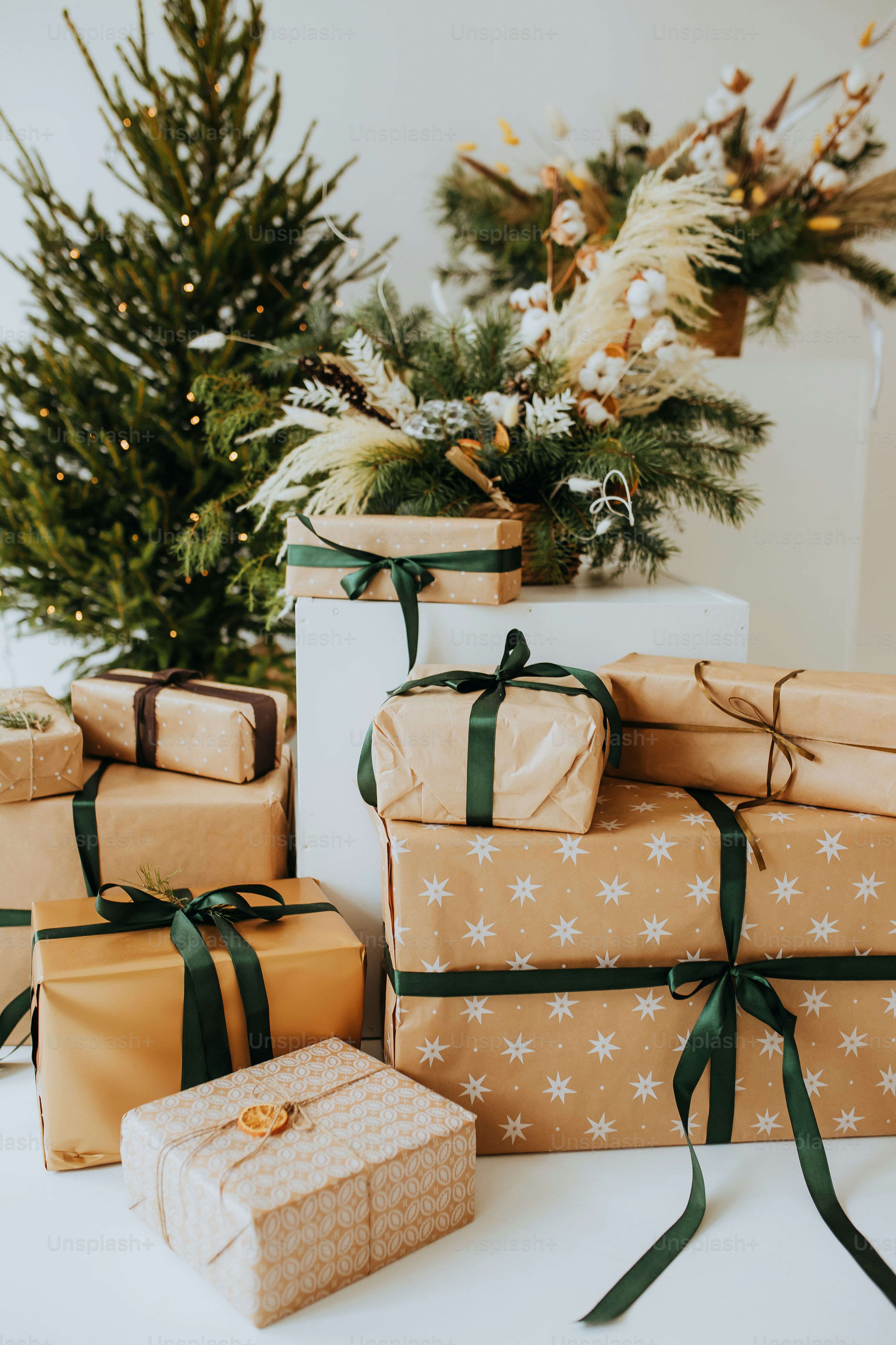 A group of wrapped presents sitting next to a christmas tree photo ...