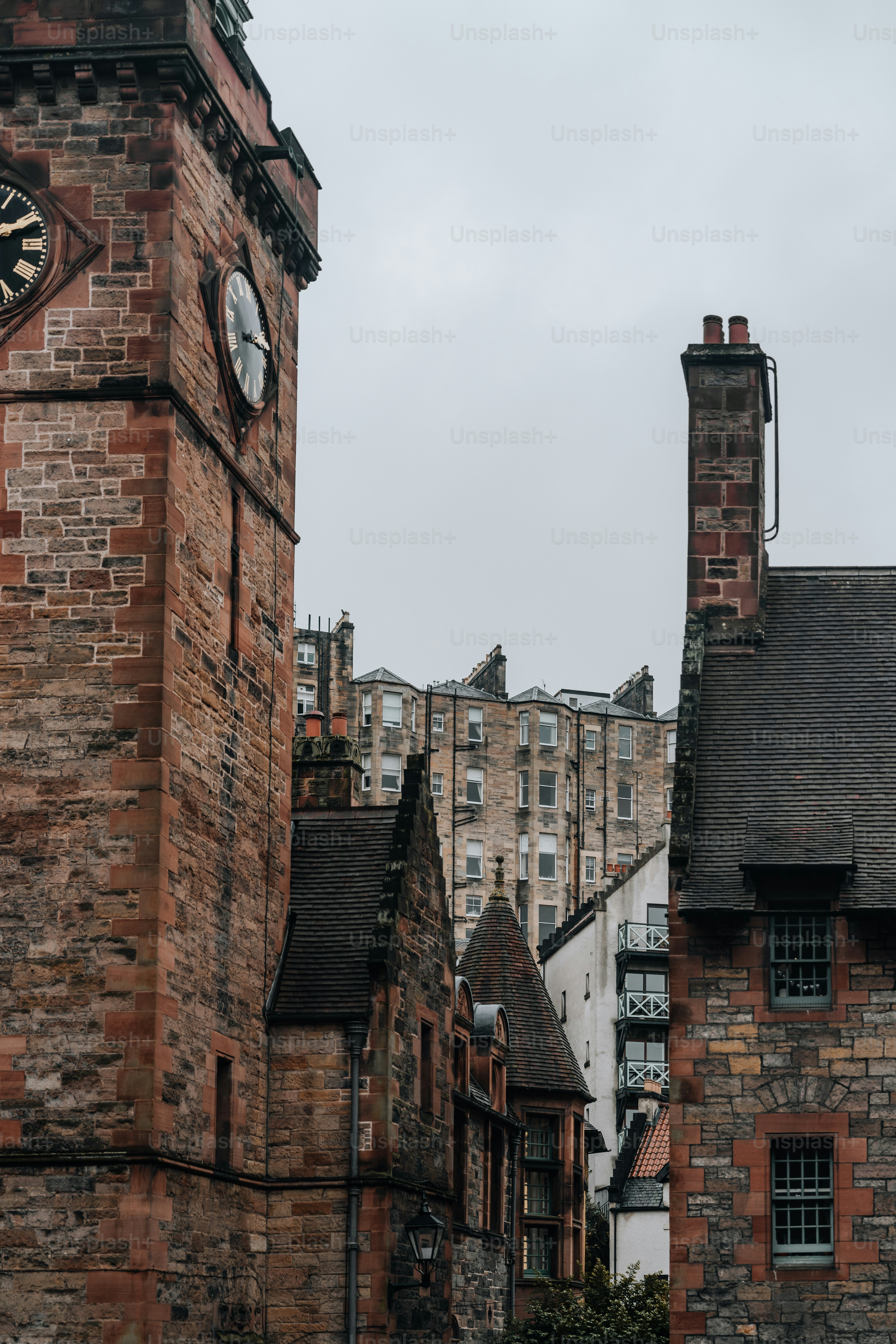 A brick building with a clock on the side of it photo – Edinburgh Image ...