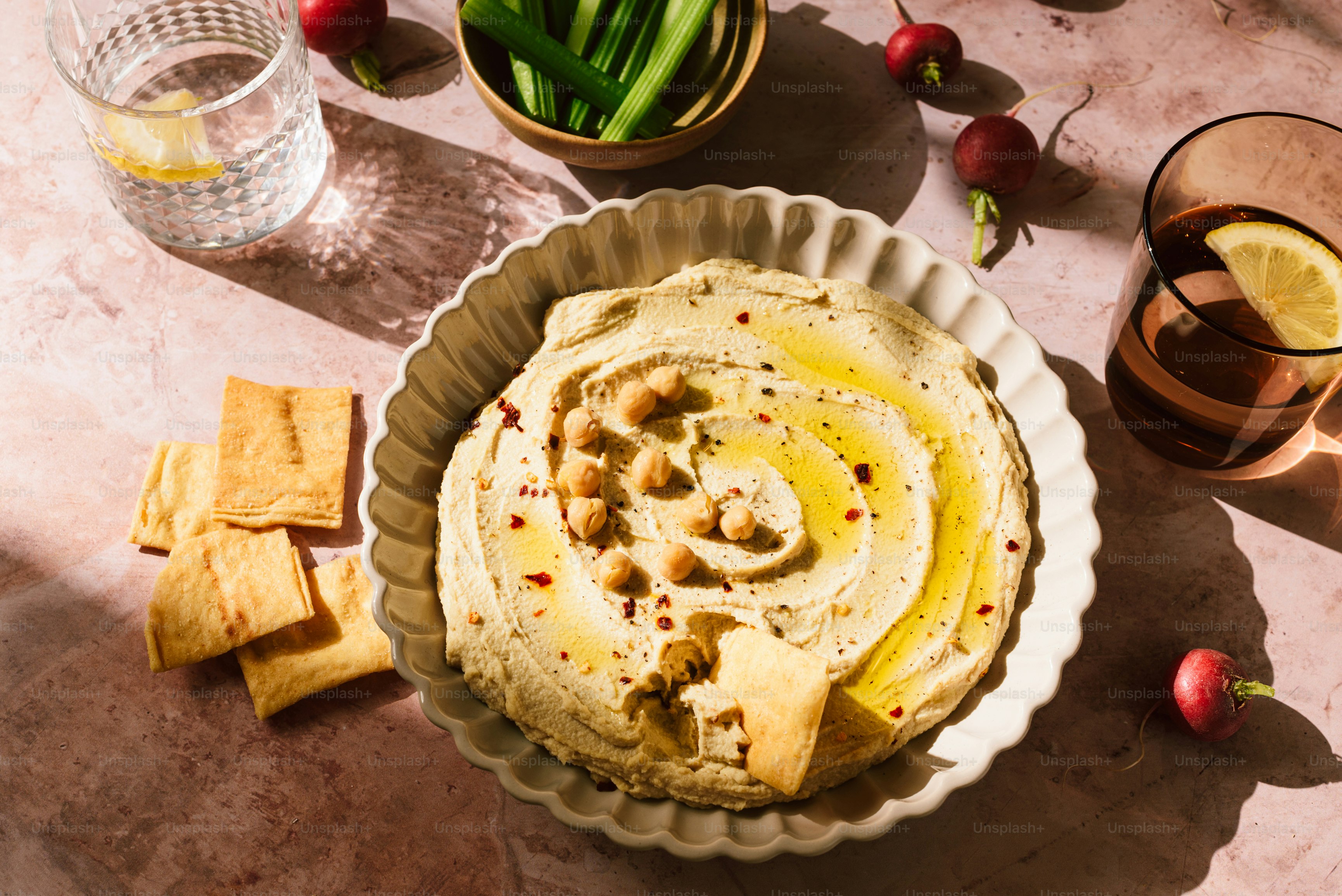 Foto Un bol de hummus junto a un bol de galletas saladas y un vaso de ...