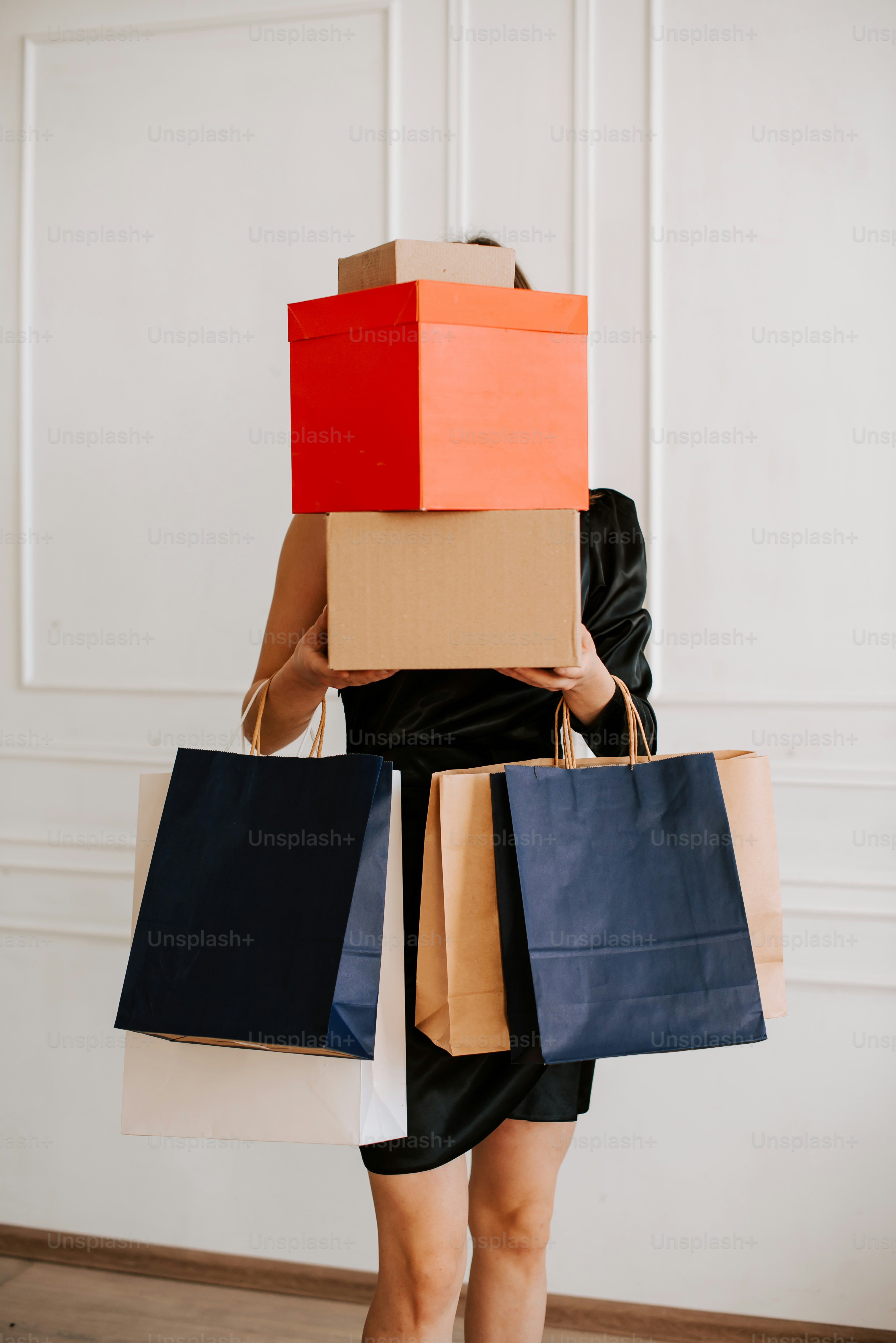 A woman carrying a stack of boxes on her back photo – Sales season ...