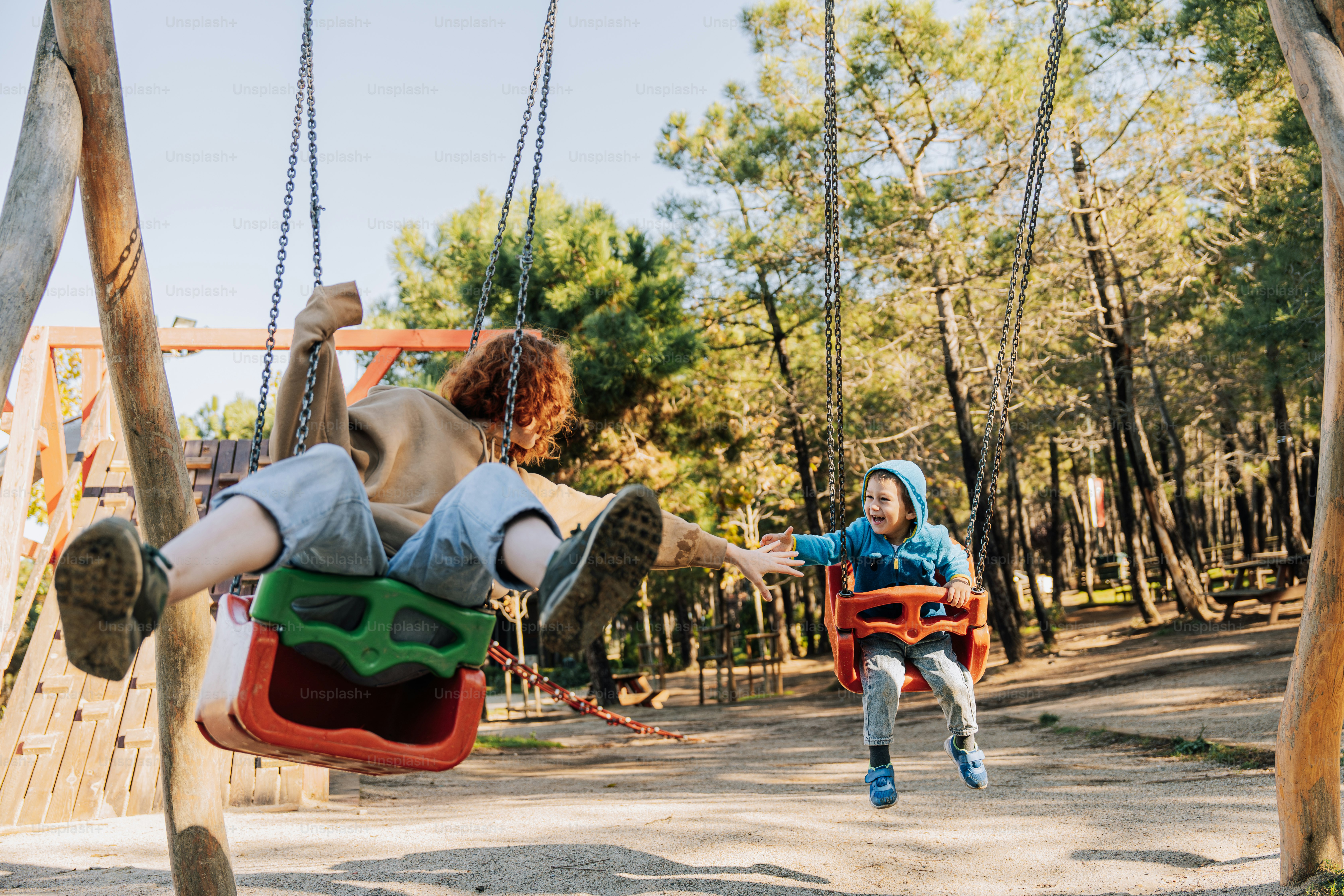 Two children playing on swings in a park photo – Family Image on Unsplash