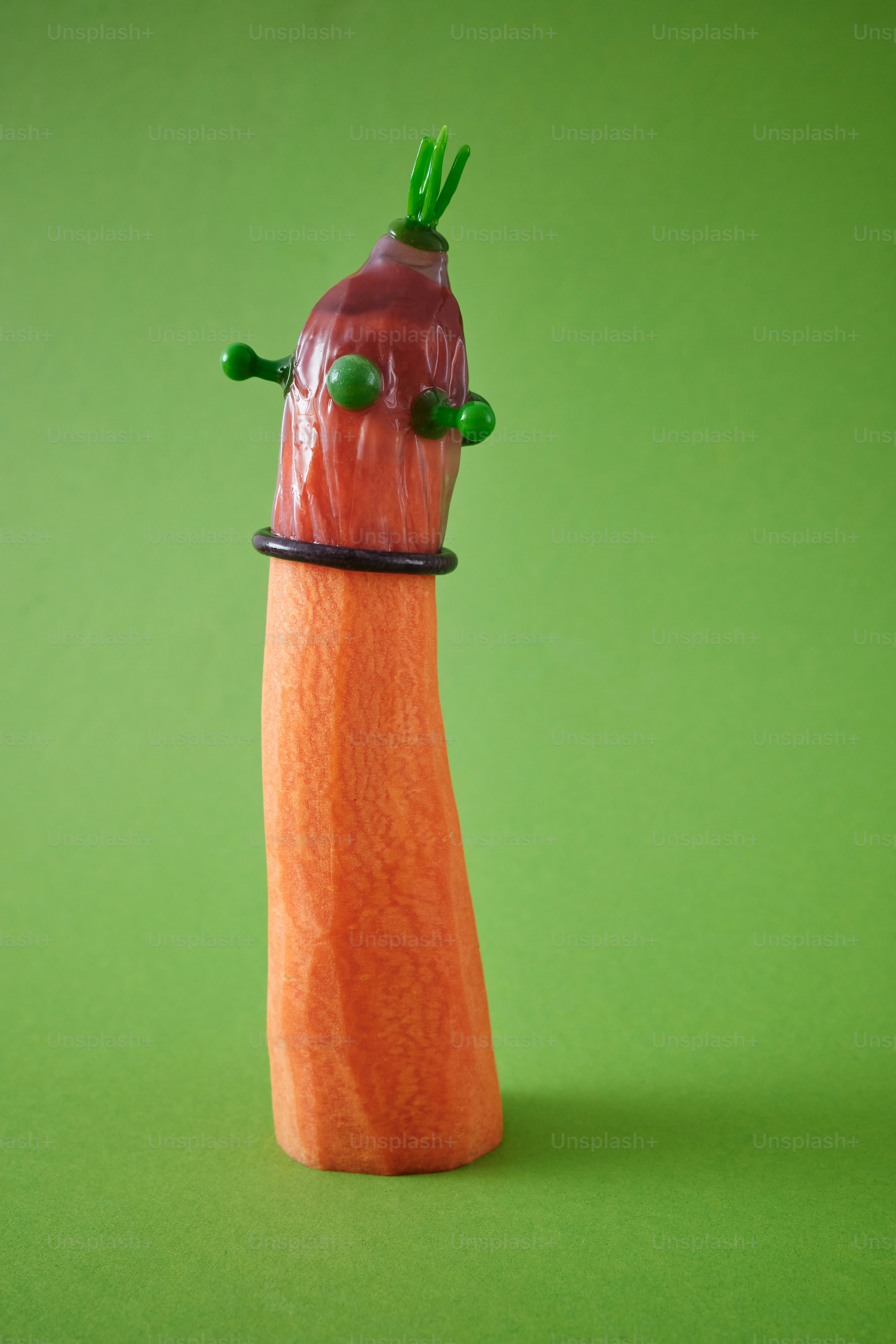 A carrot with a green stem sticking out of it photo – Condom Image on ...
