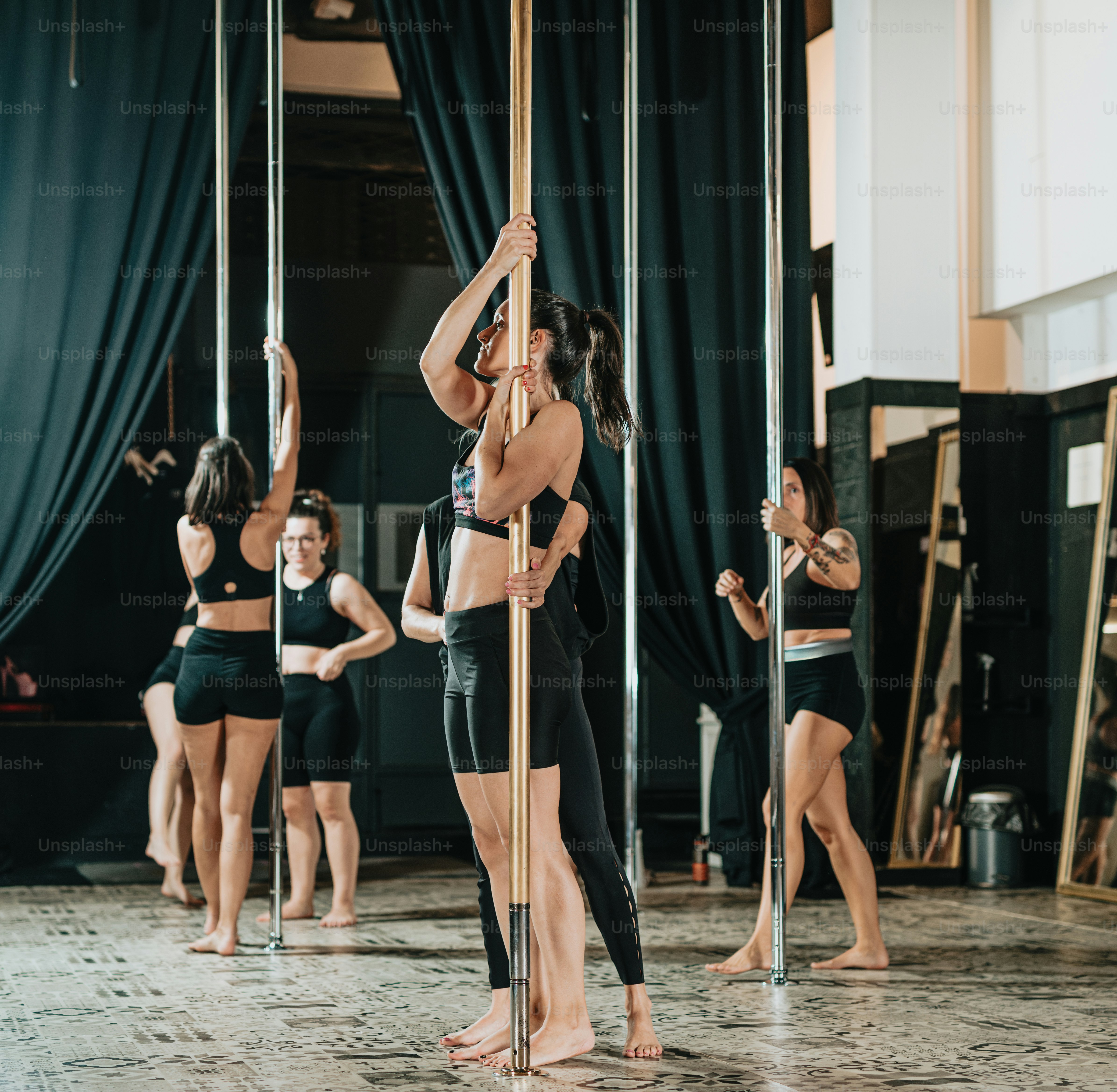 A group of women standing around a pole photo – Training Image on Unsplash