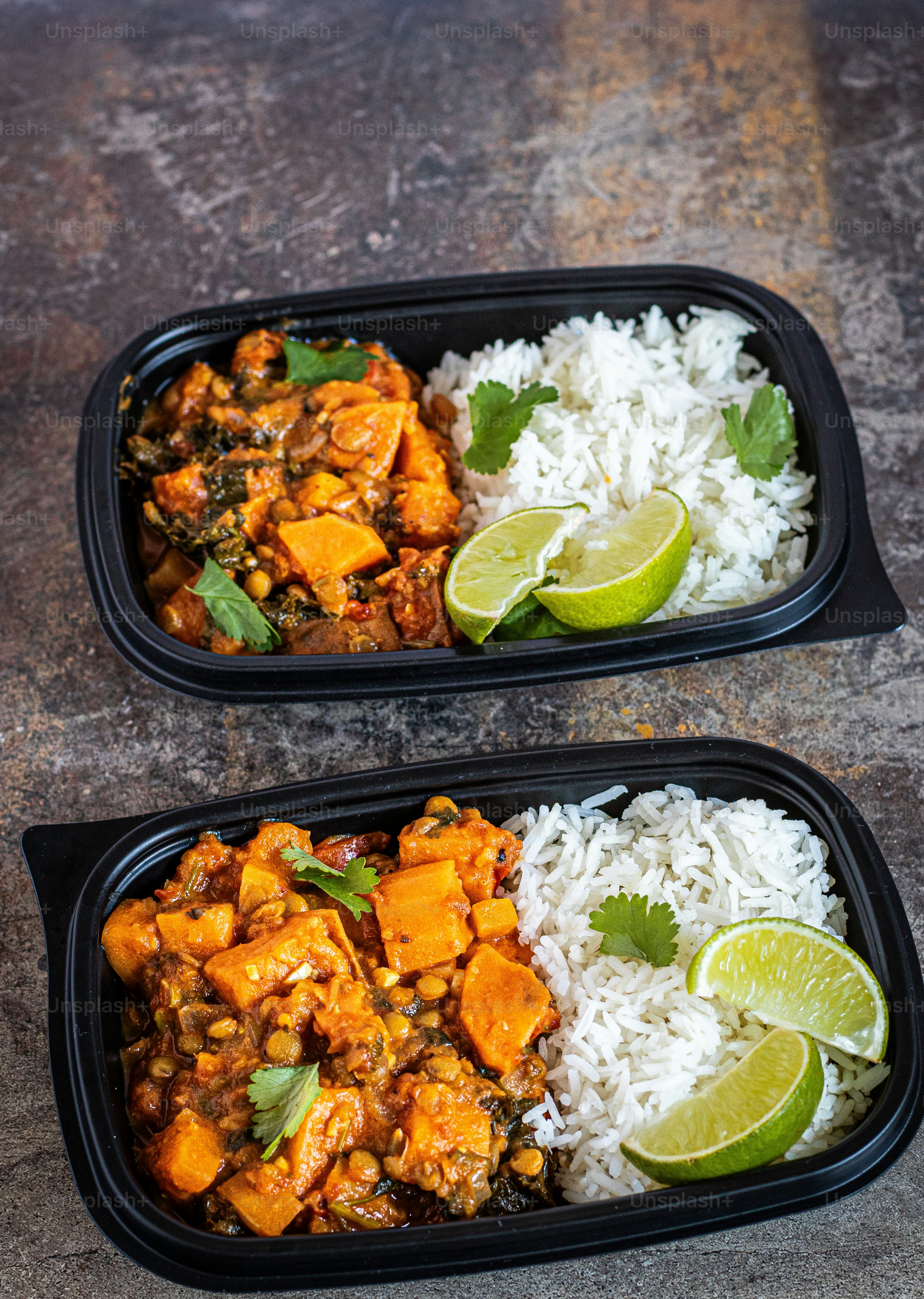 Two black trays filled with rice and curry photo – Meal prep Image on ...