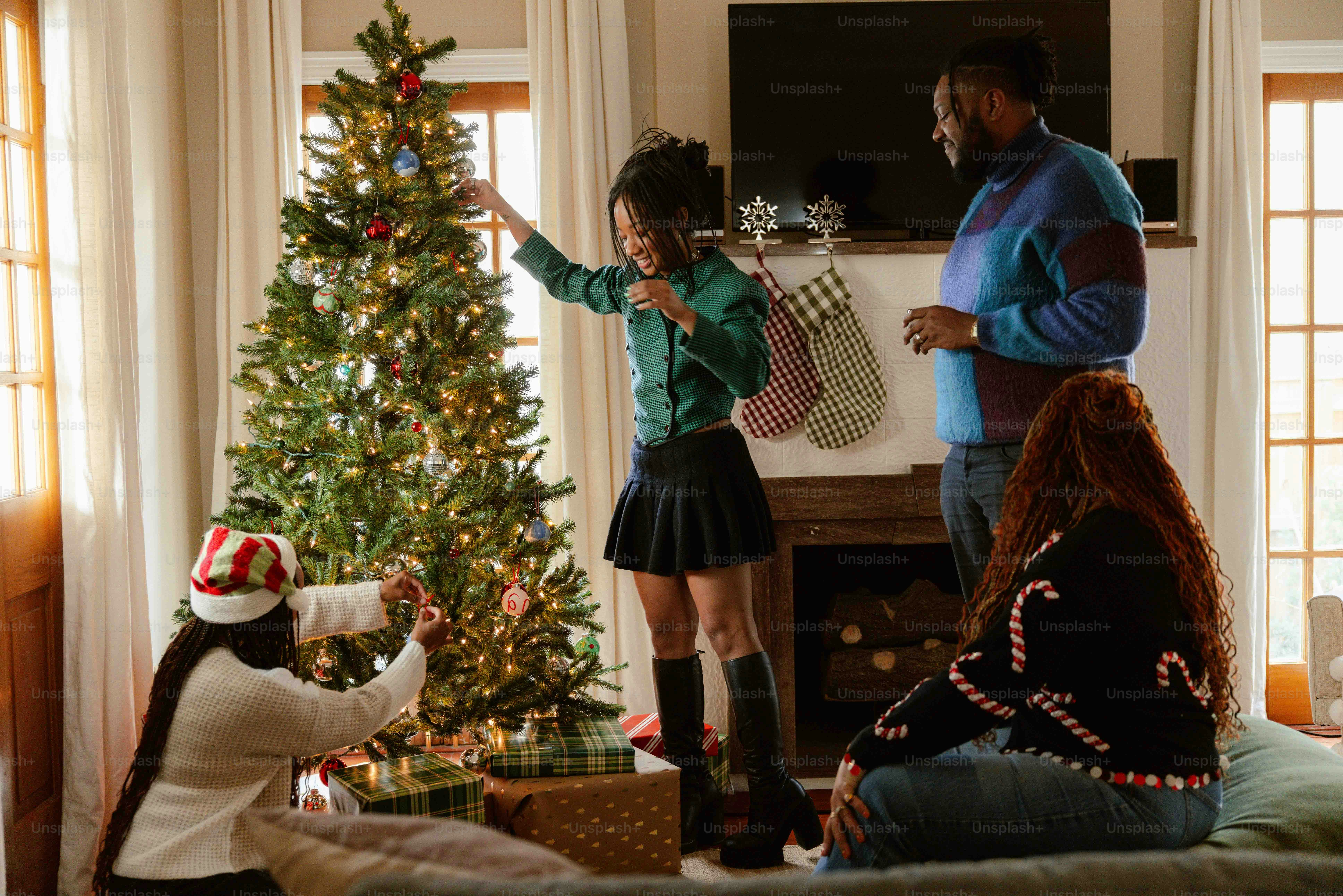 A group of people standing around a christmas tree photo – Christmas ...
