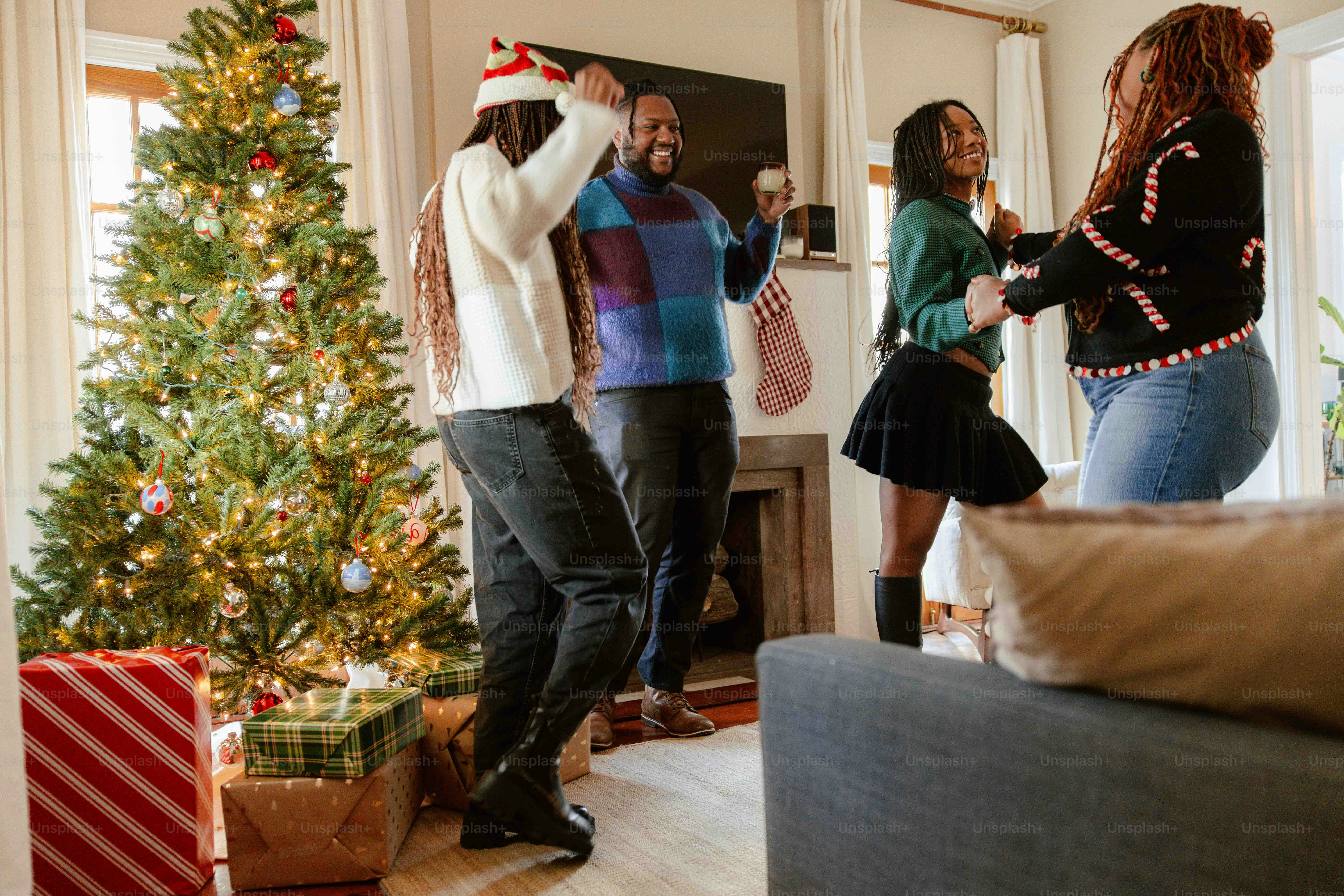 A group of people standing around a christmas tree photo – Christmas ...