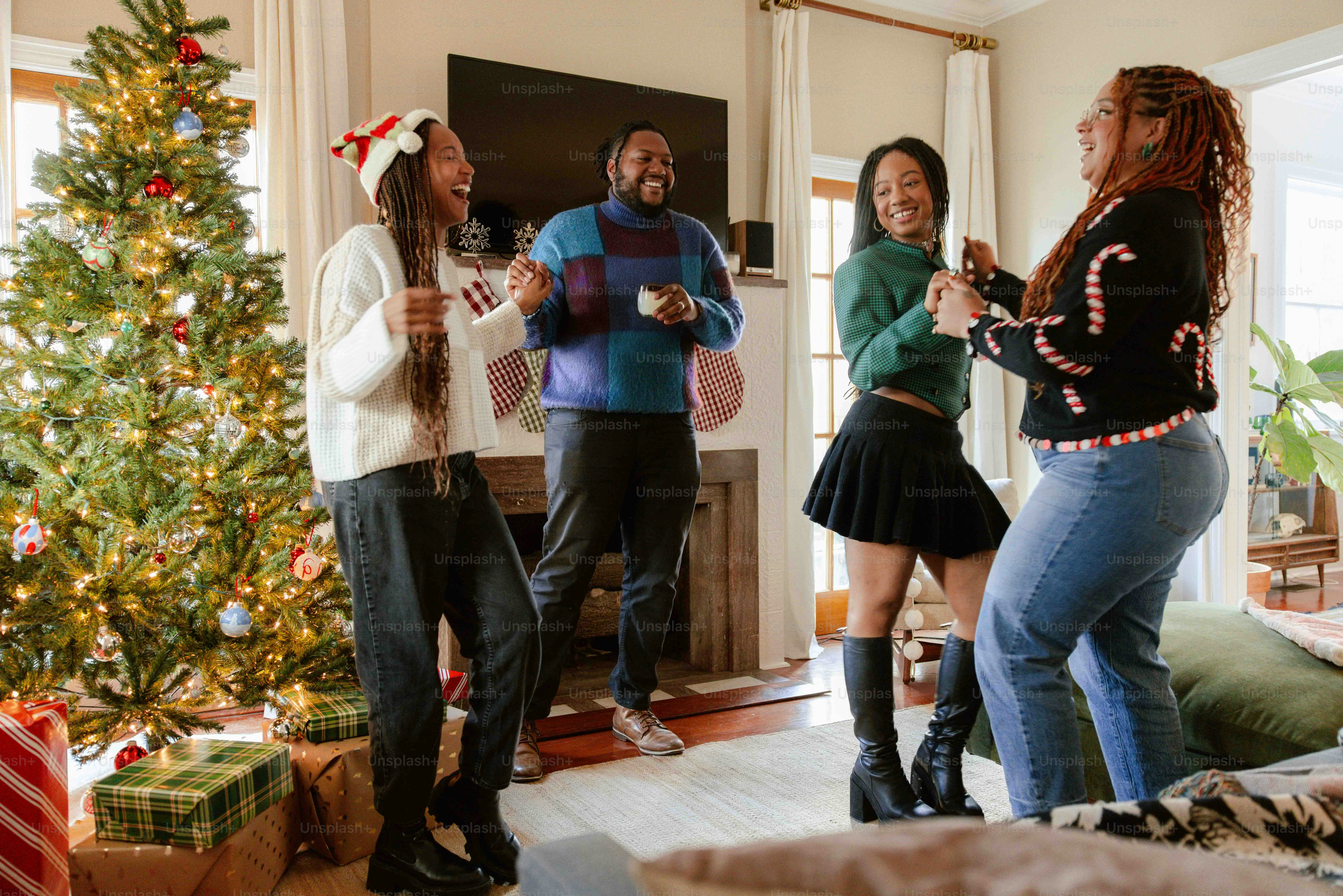 A group of people standing around a christmas tree photo – Party Image ...