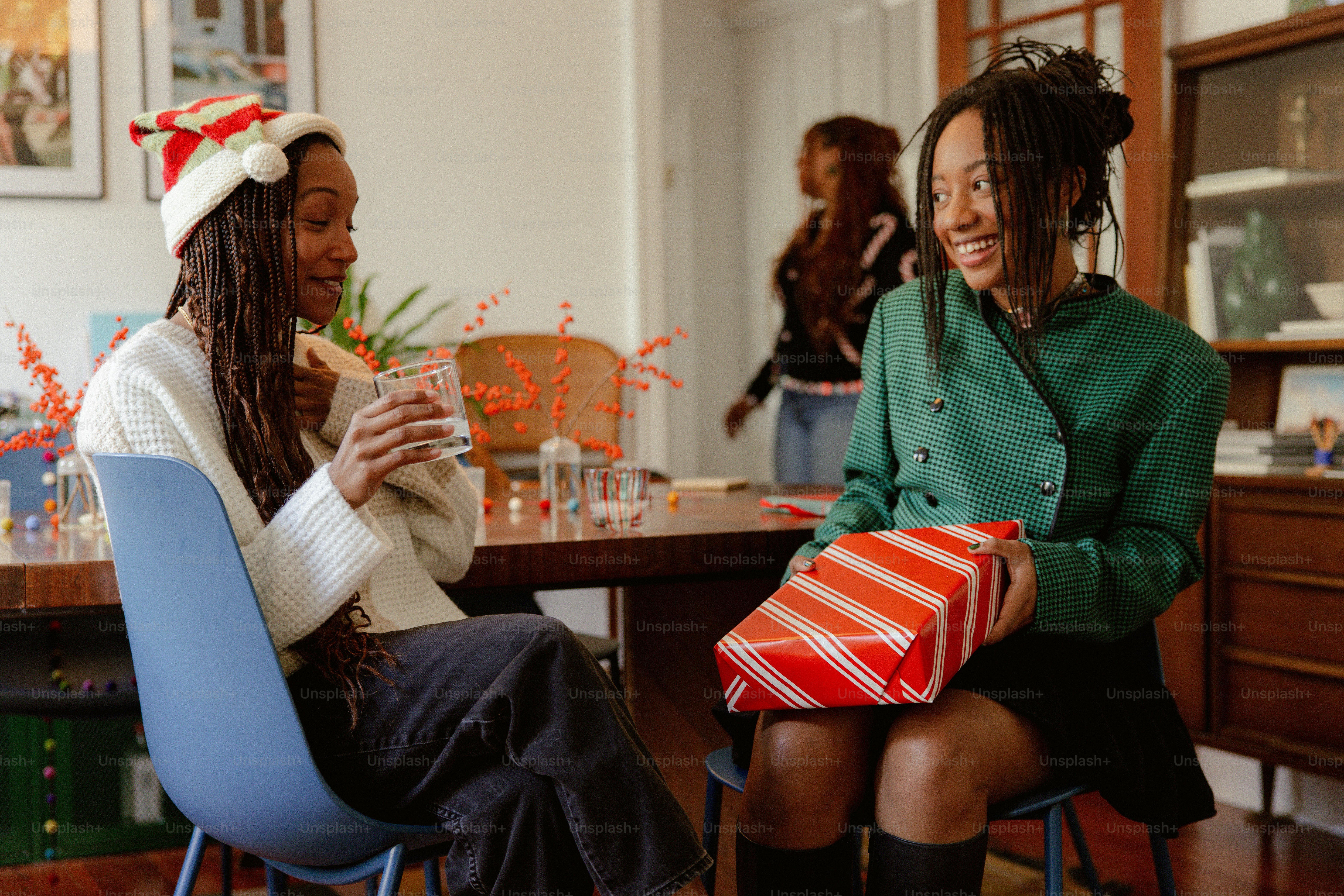 Two women sitting at a table with presents photo – Christmas gifts ...