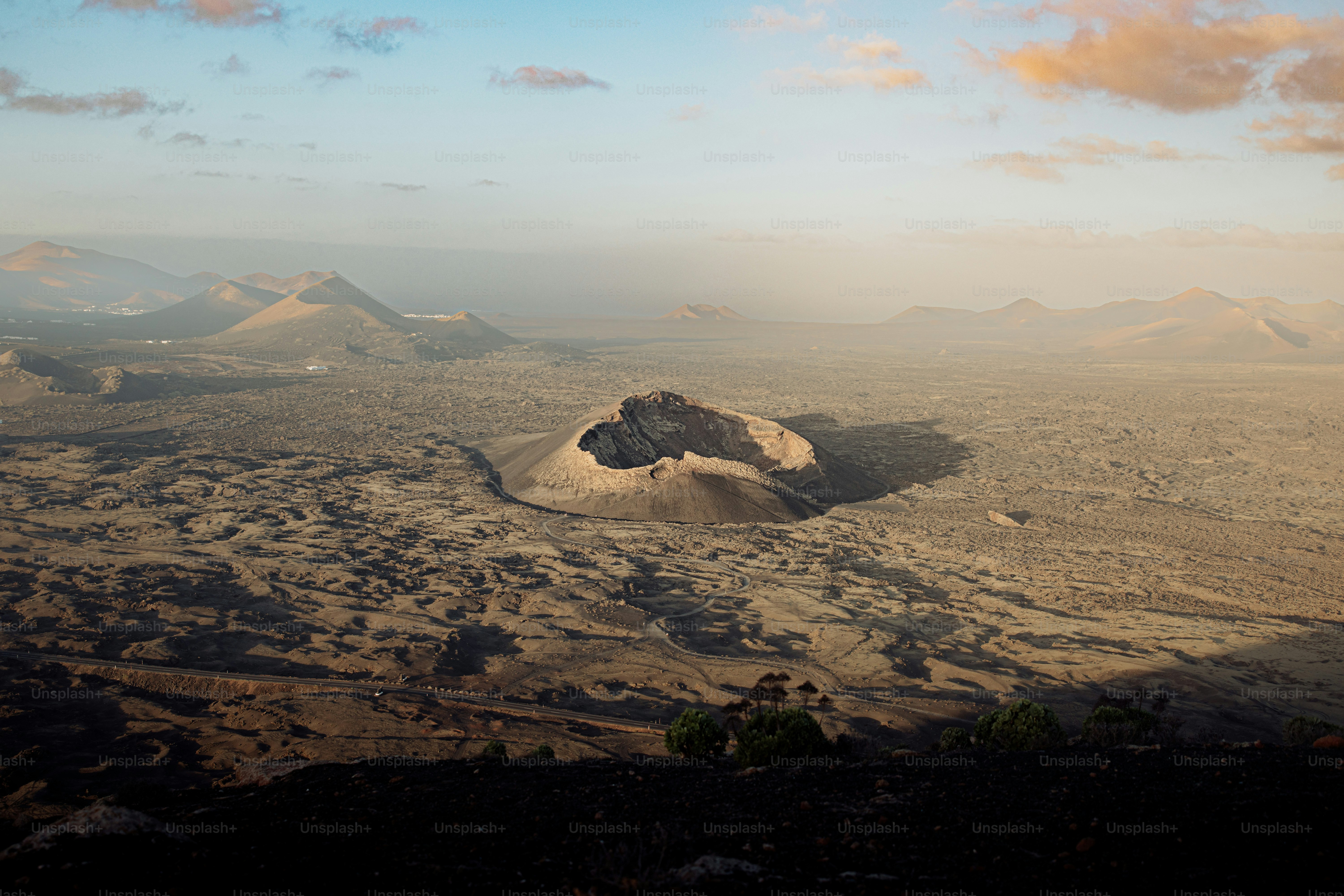 A barren landscape with mountains in the distance photo – Volcano Image ...