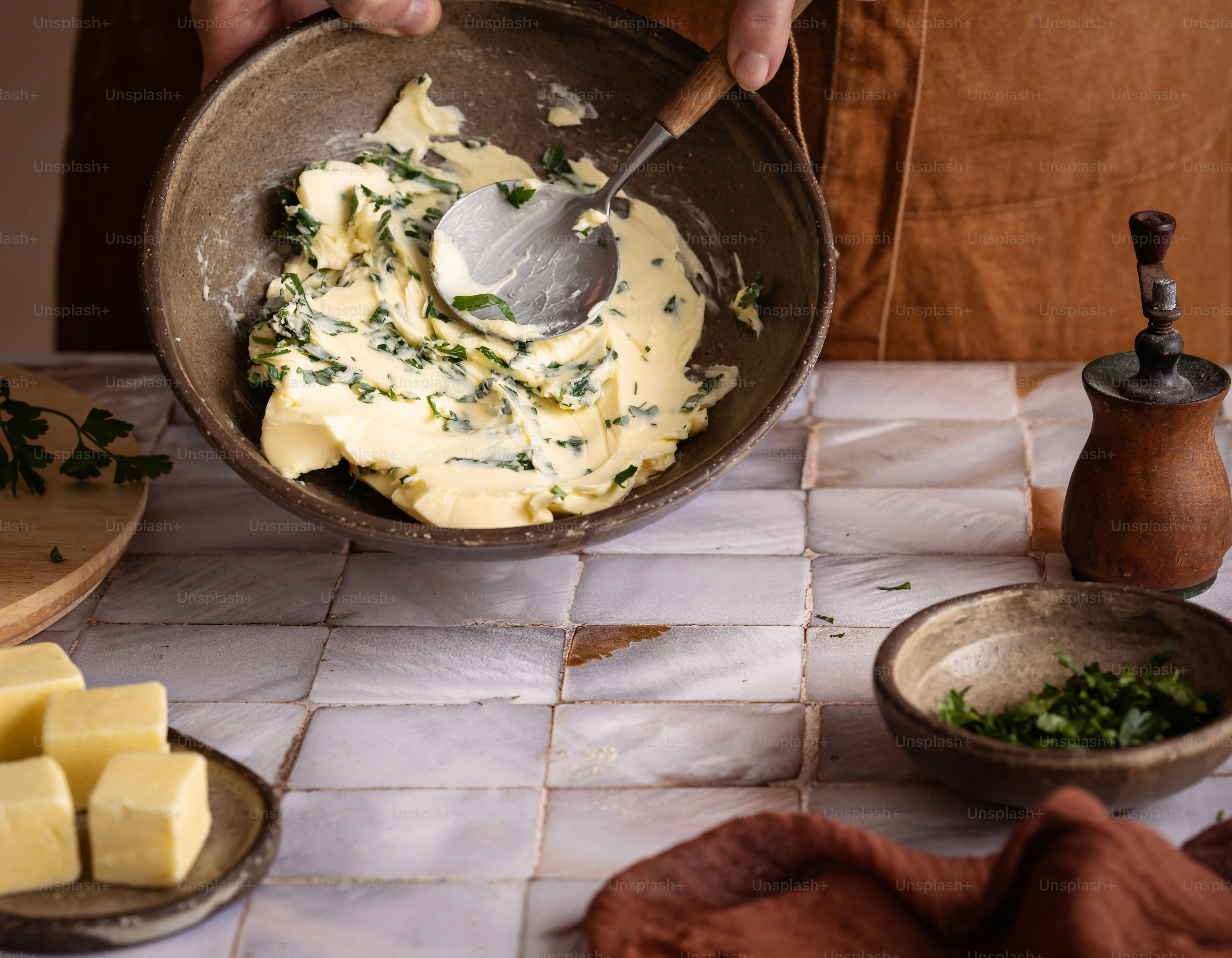 A person mixing a bowl of food with a spoon photo – Herb butter Image ...