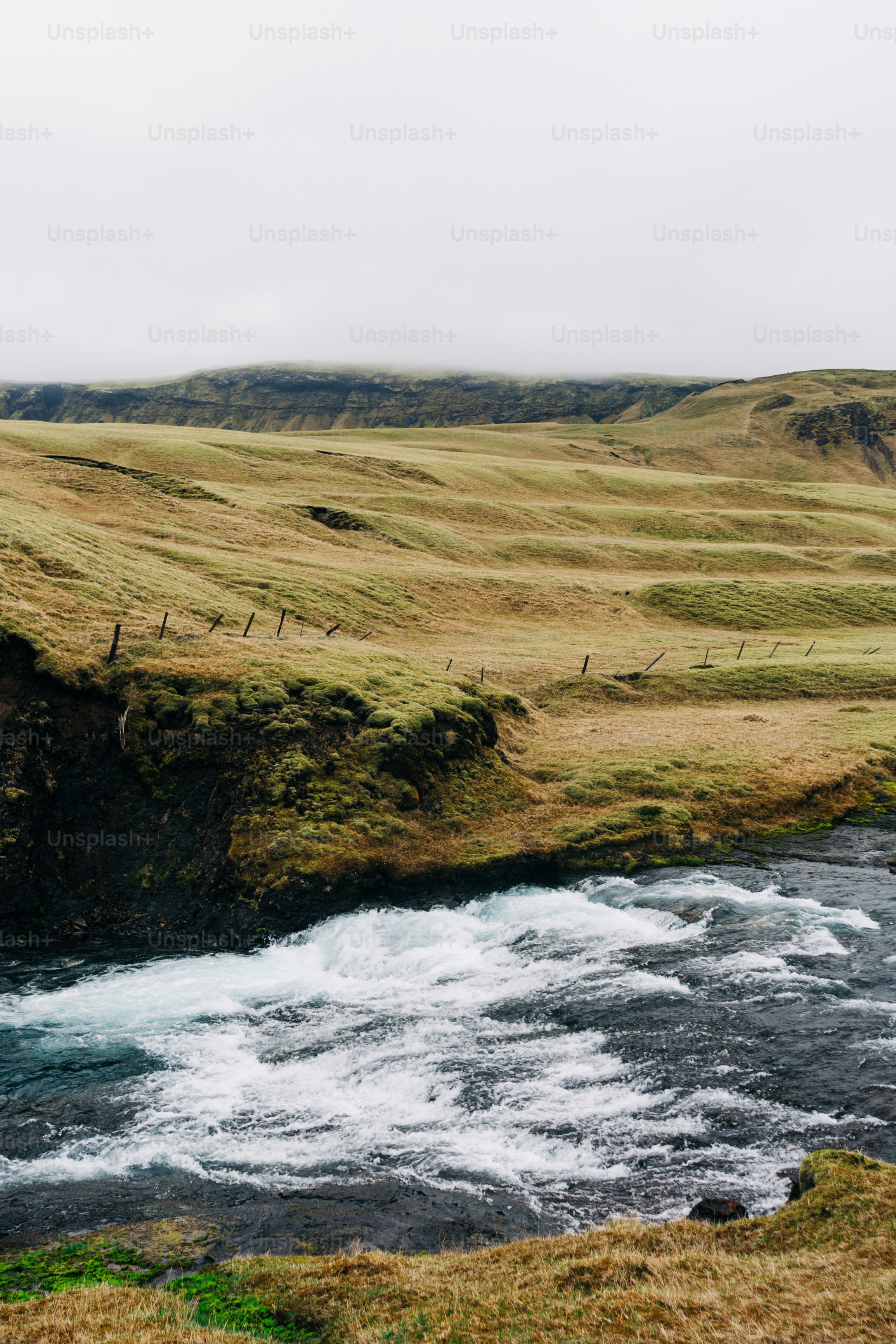 A river running through a lush green hillside photo – Iceland Image on ...