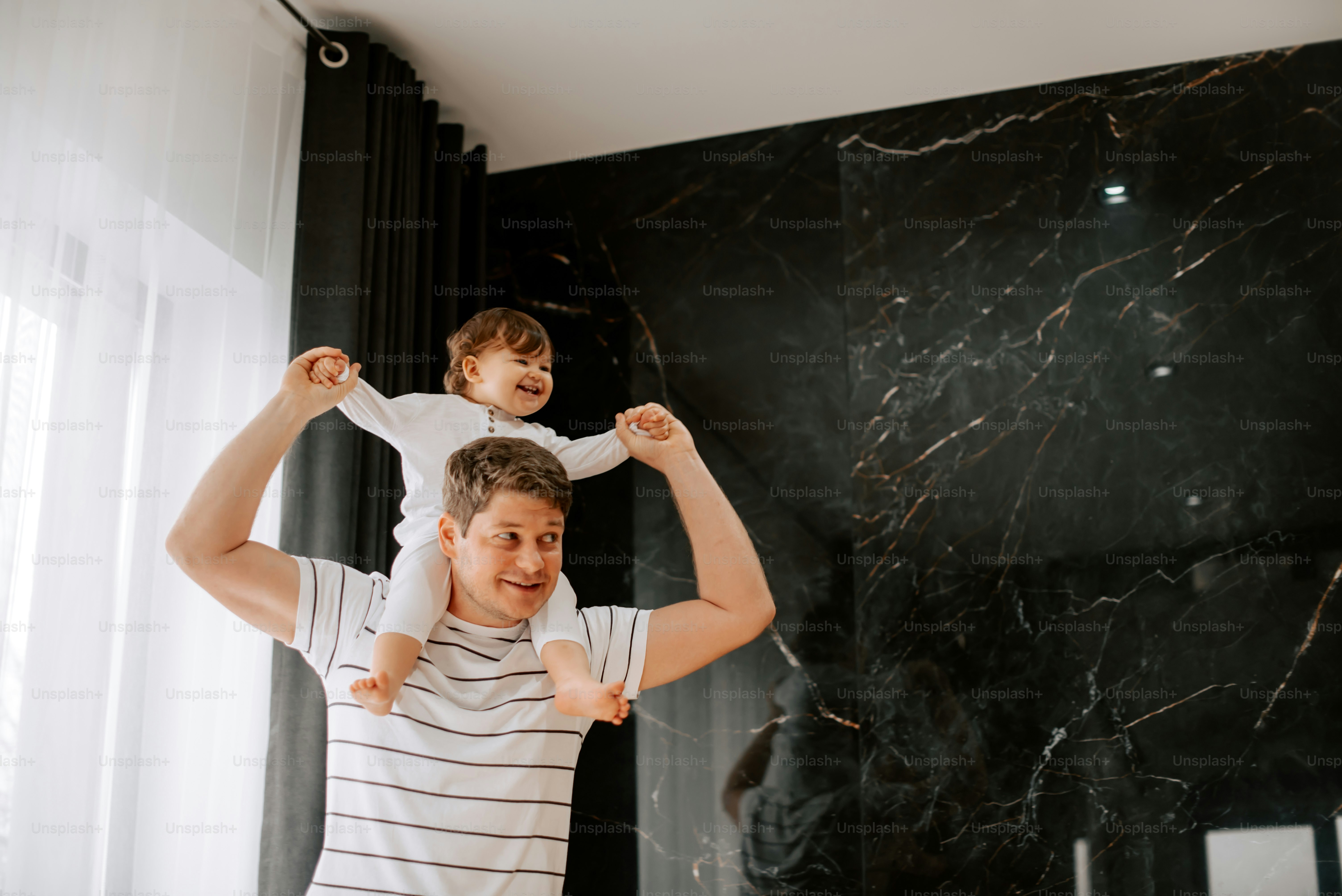 A man holding a child on his shoulders photo – Riding on shoulders ...