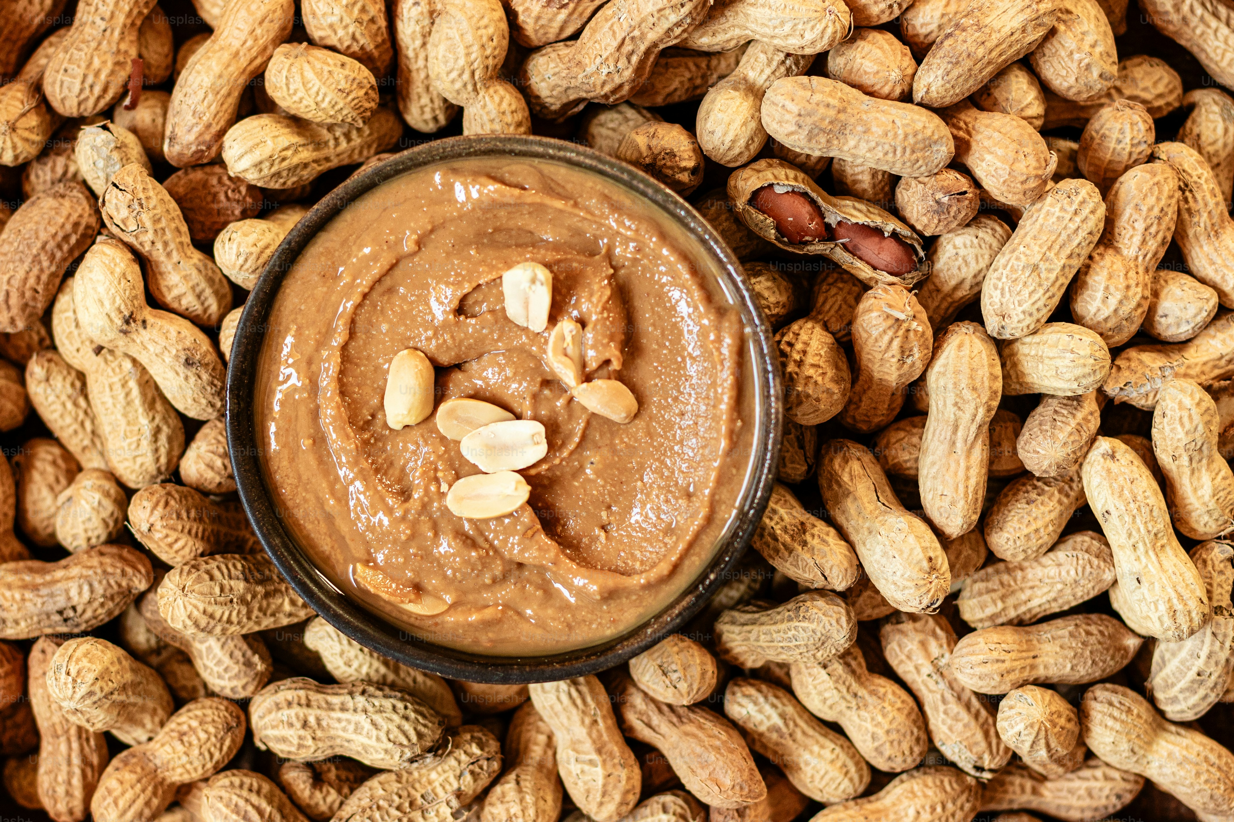A bowl of peanut butter surrounded by peanuts photo – Food styling ...