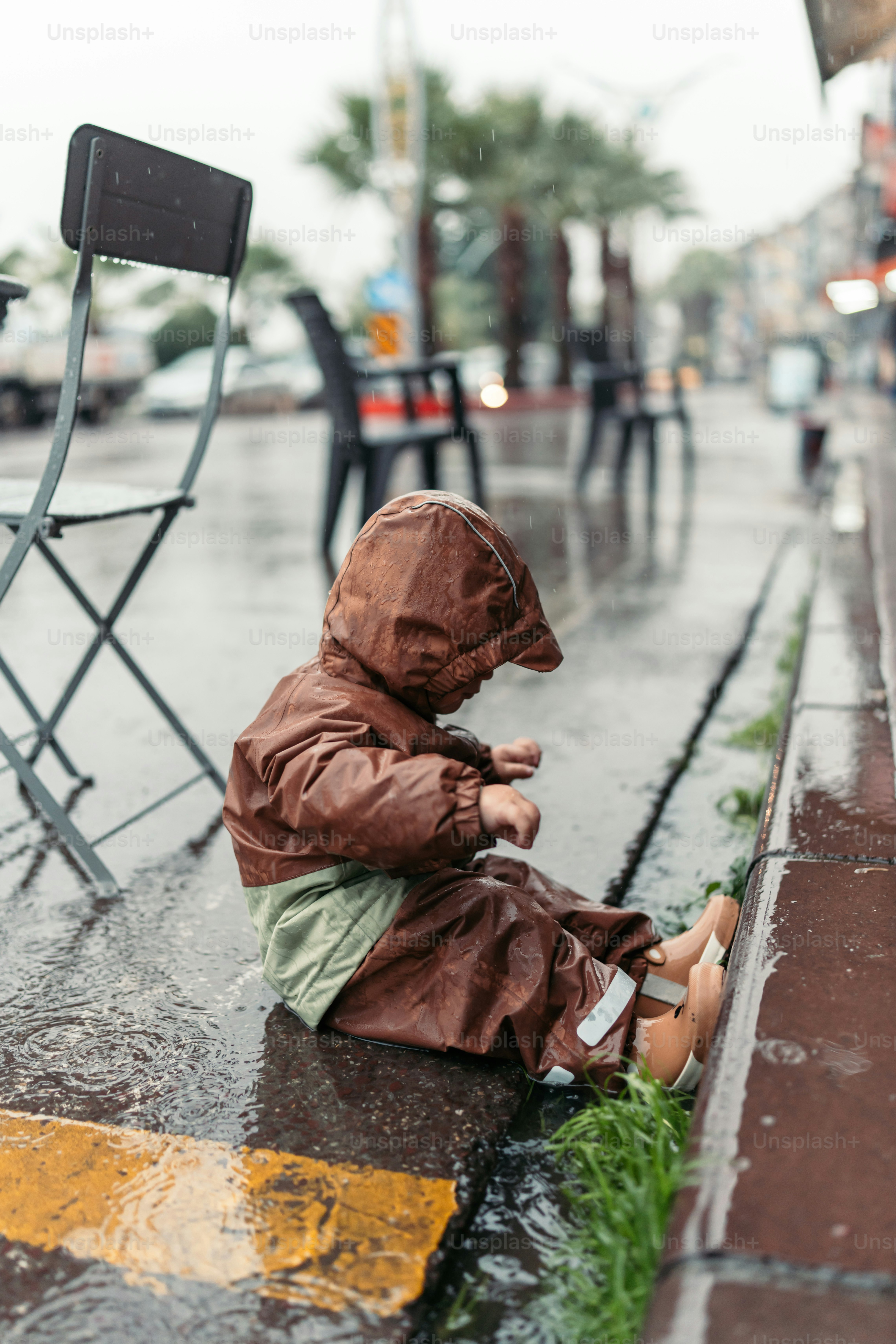 A small child sitting on the ground next to a chair photo – Family ...