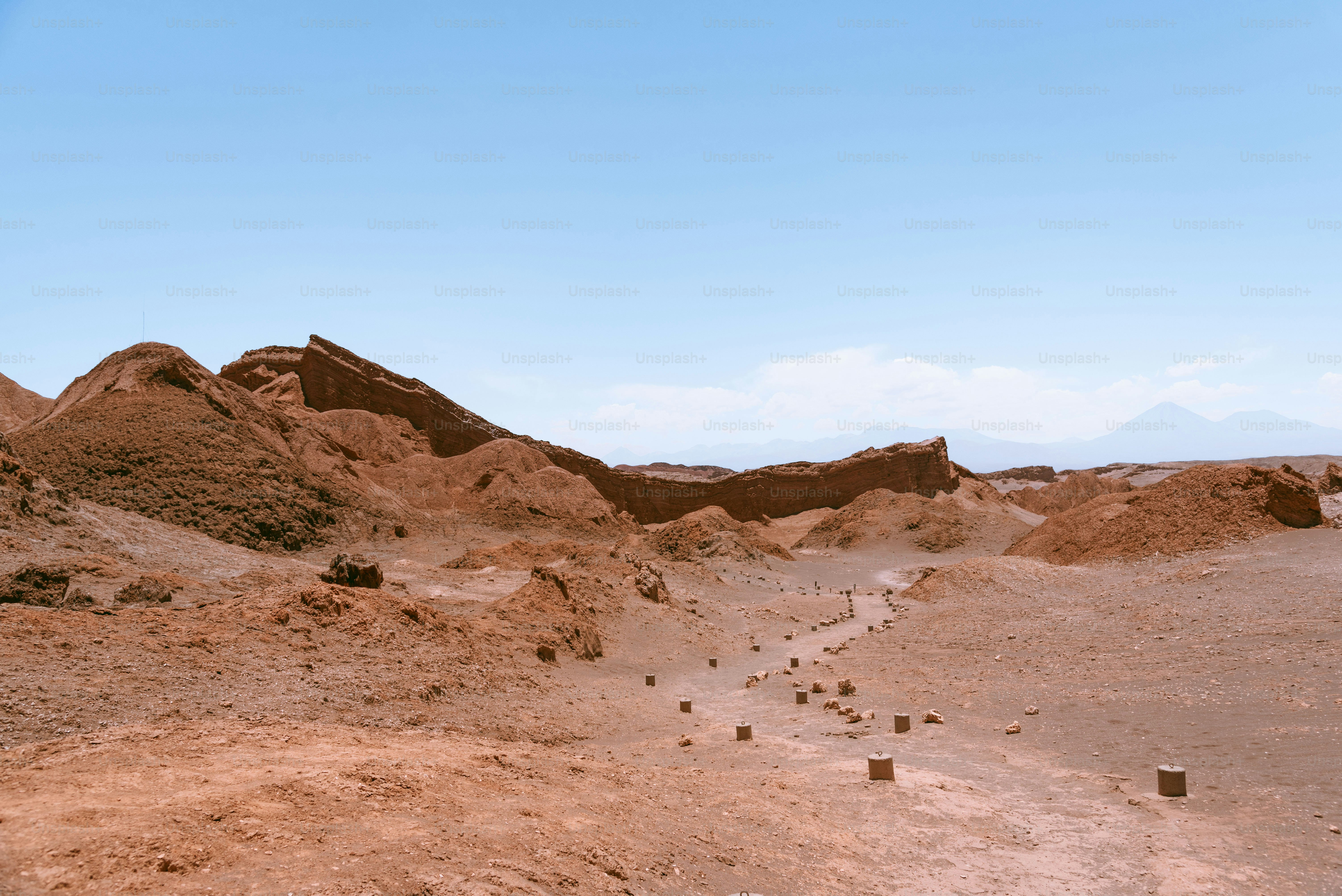 A dirt field with a mountain in the background photo – Atacama Image on ...