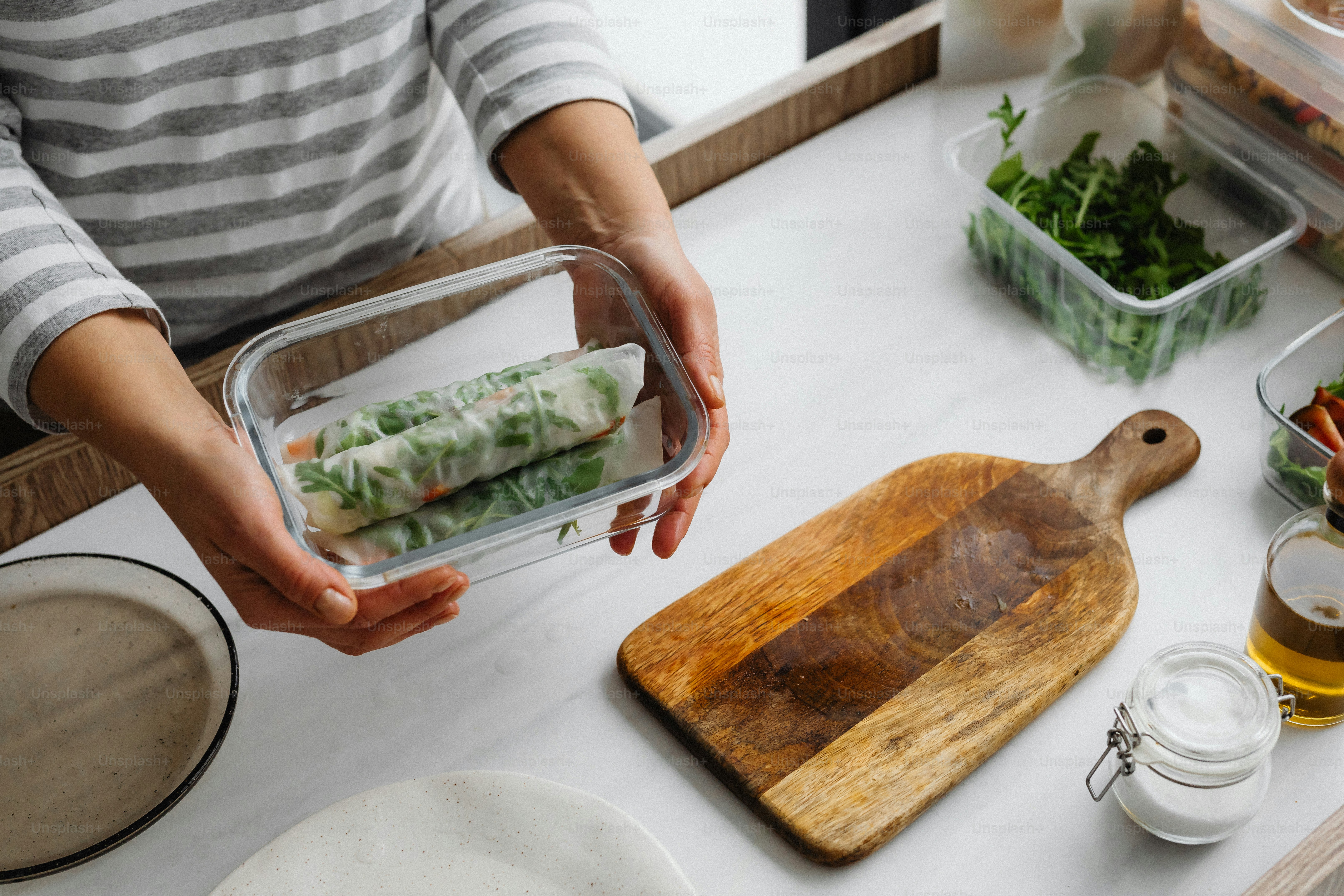 A person holding a container filled with food photo – Meal prepping ...