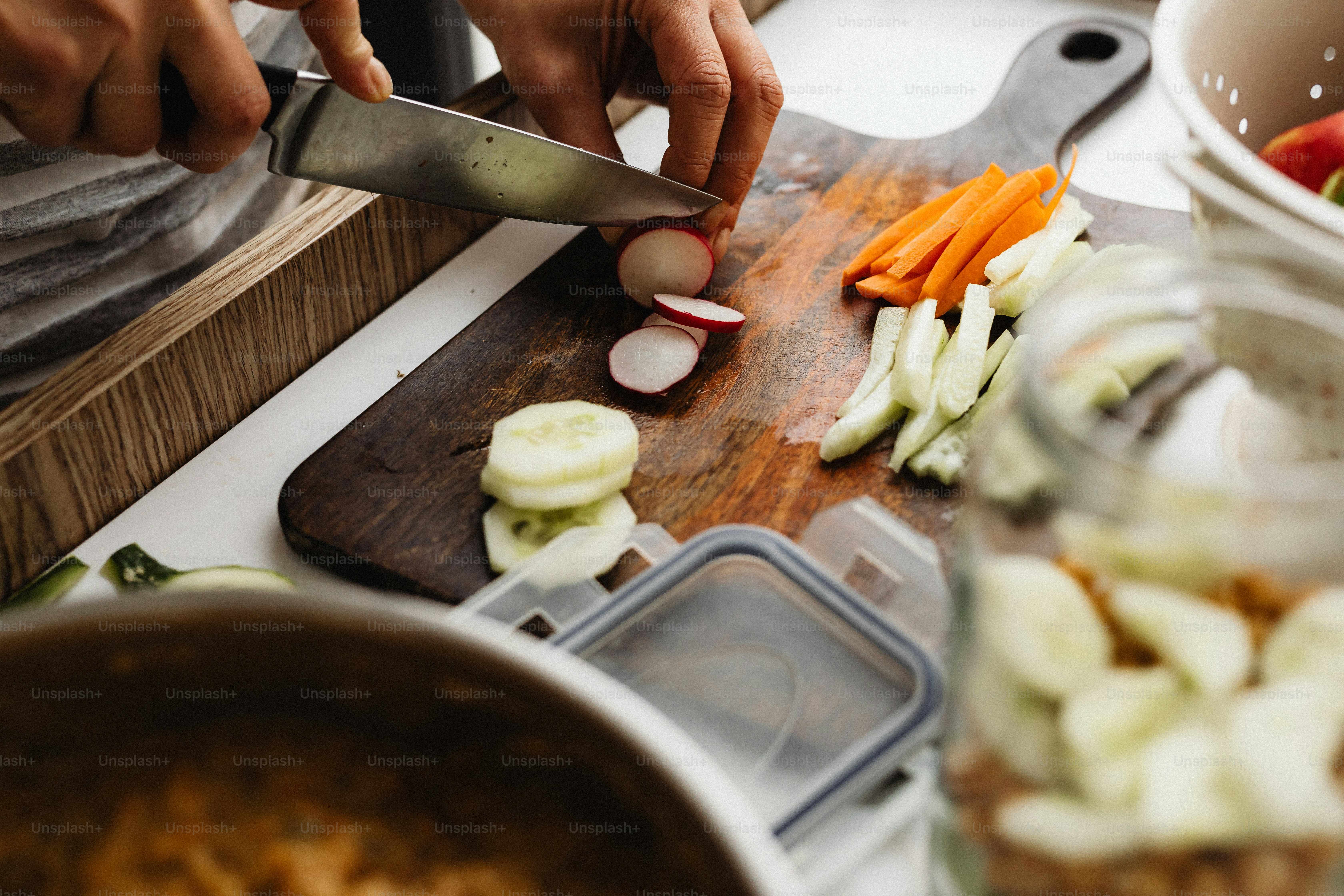A person cutting up vegetables on a cutting board photo – Meal prepping ...