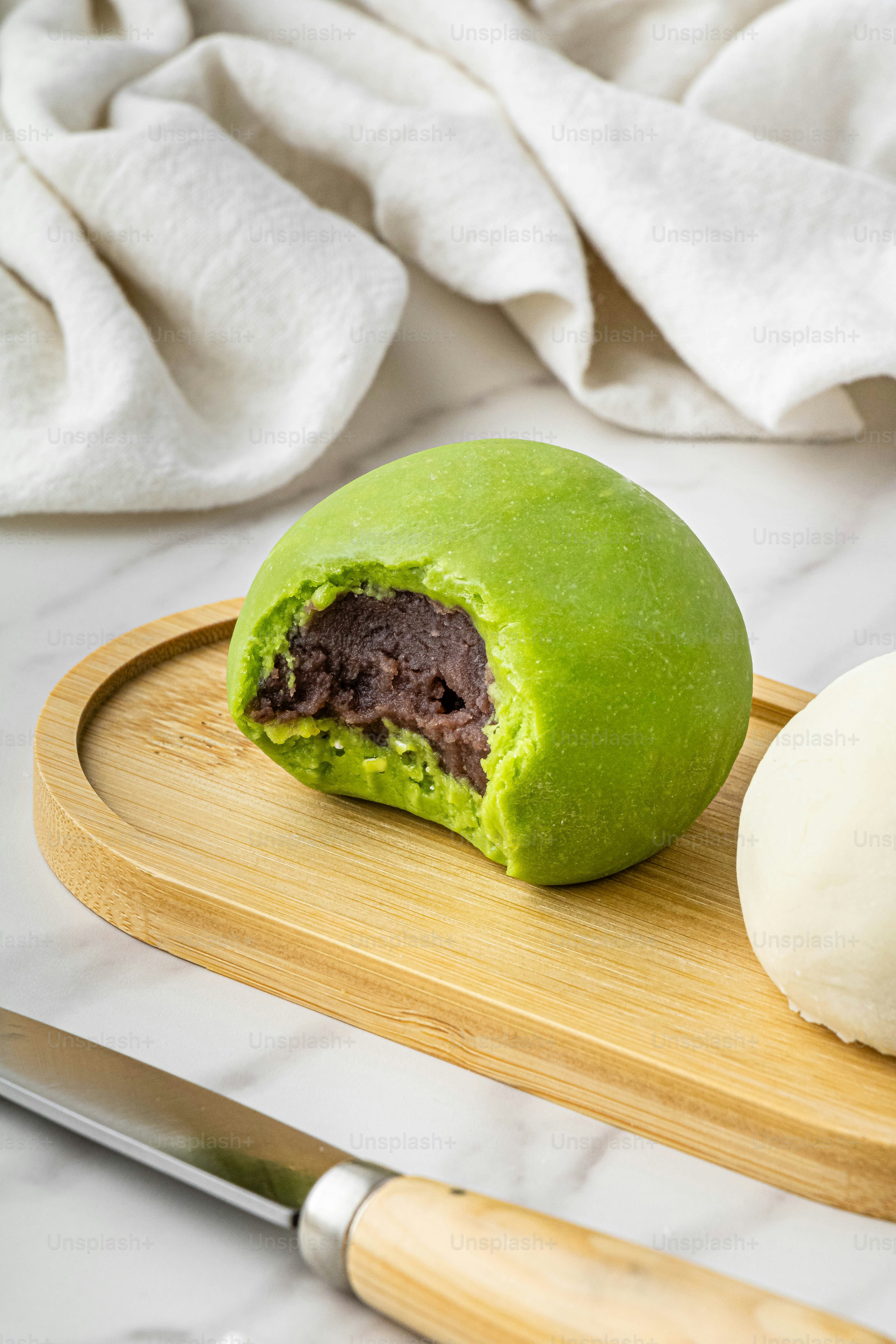 A wooden cutting board topped with a green pastry photo – Matcha Image ...