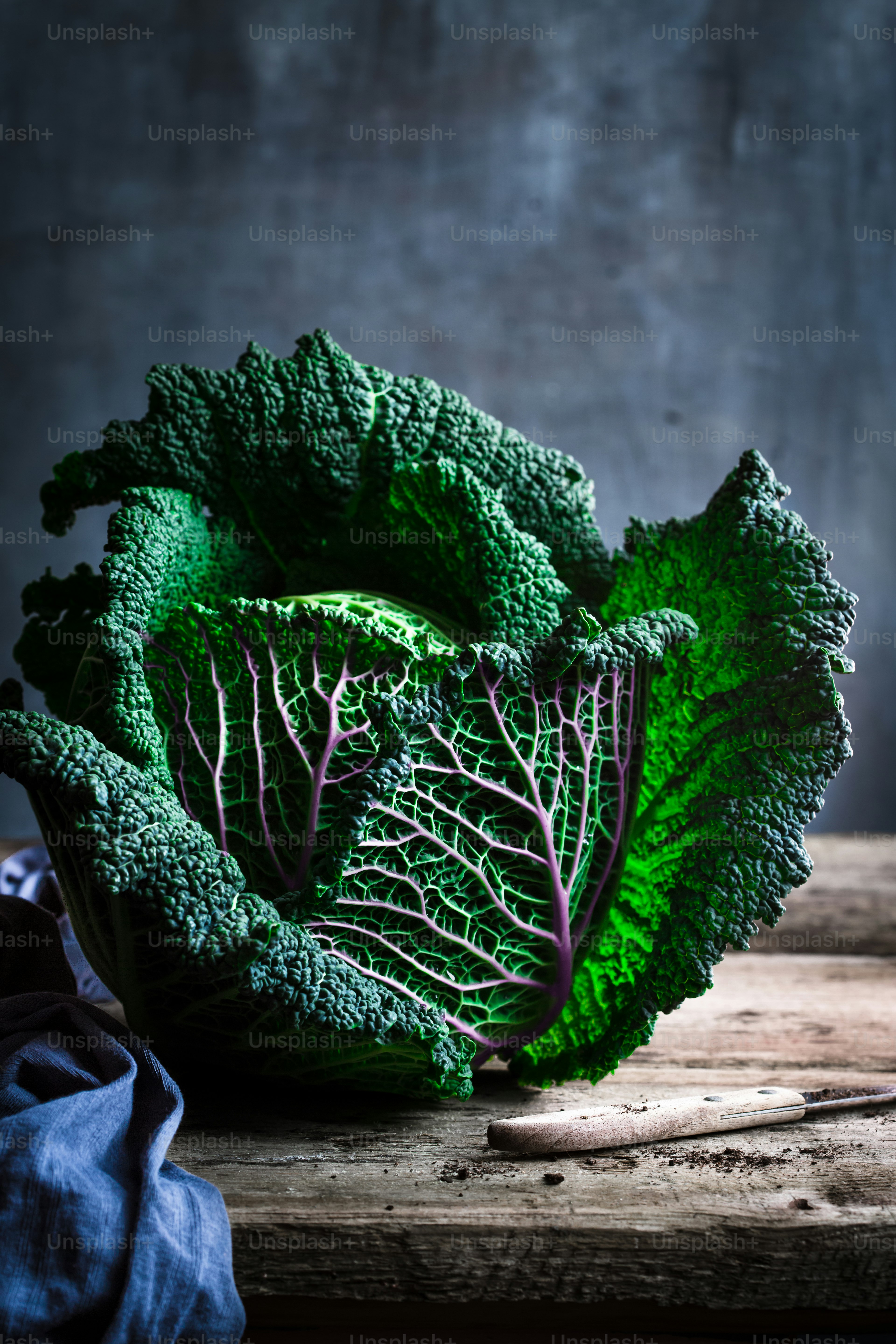 A head of broccoli sitting on top of a wooden table photo – Wallpaper ...