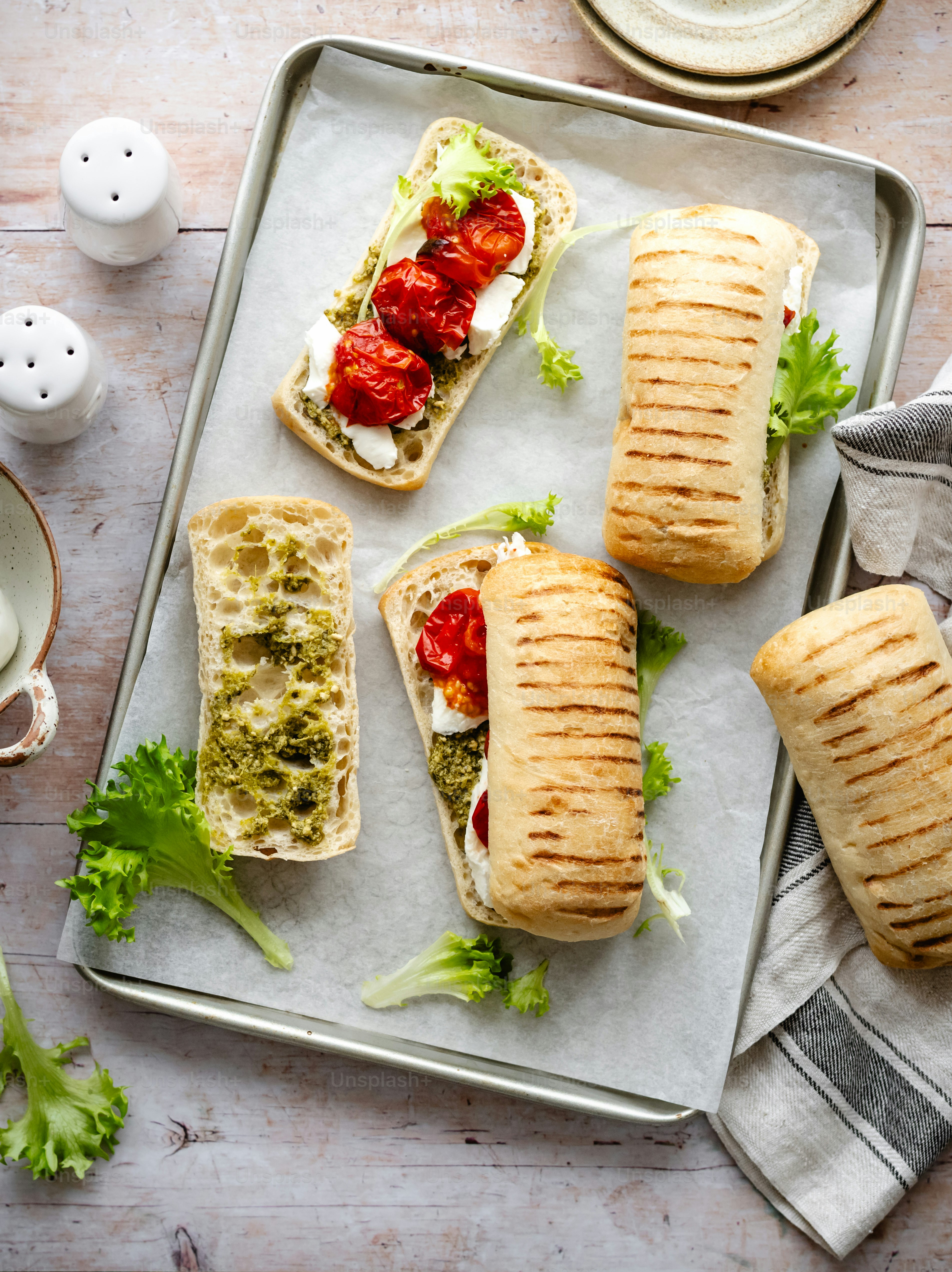 A tray filled with sandwiches on top of a wooden table photo – Panini ...