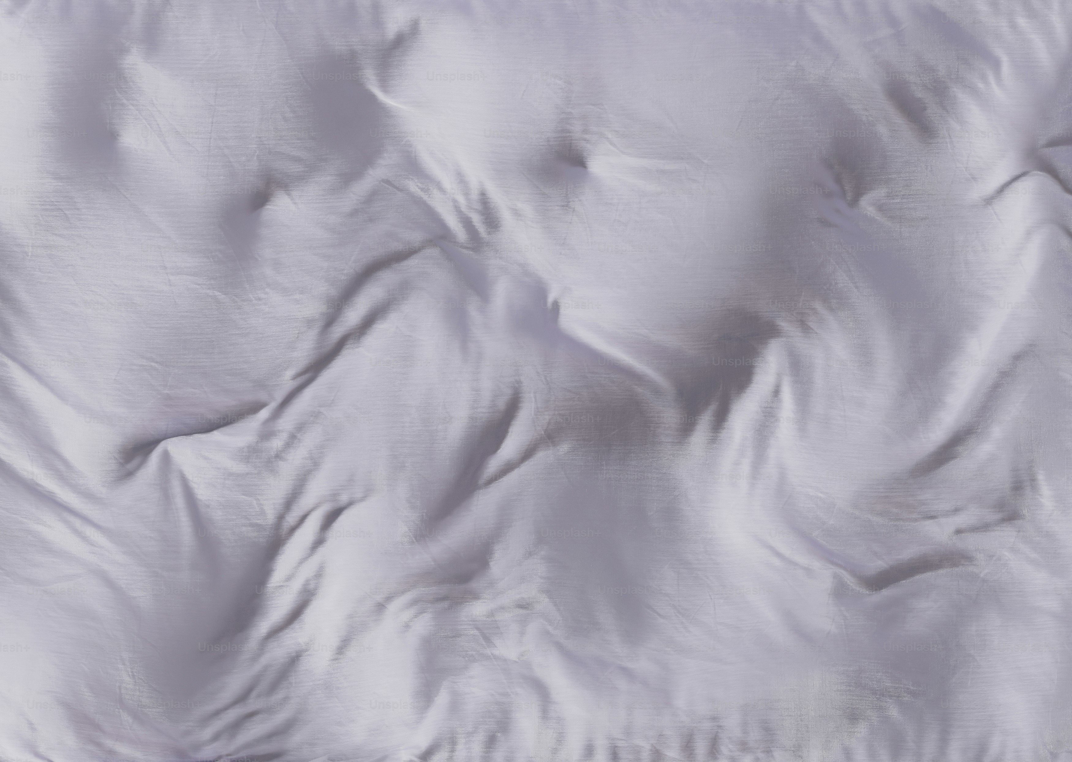A close up of a bed with a white comforter photo – Fabric Image on Unsplash