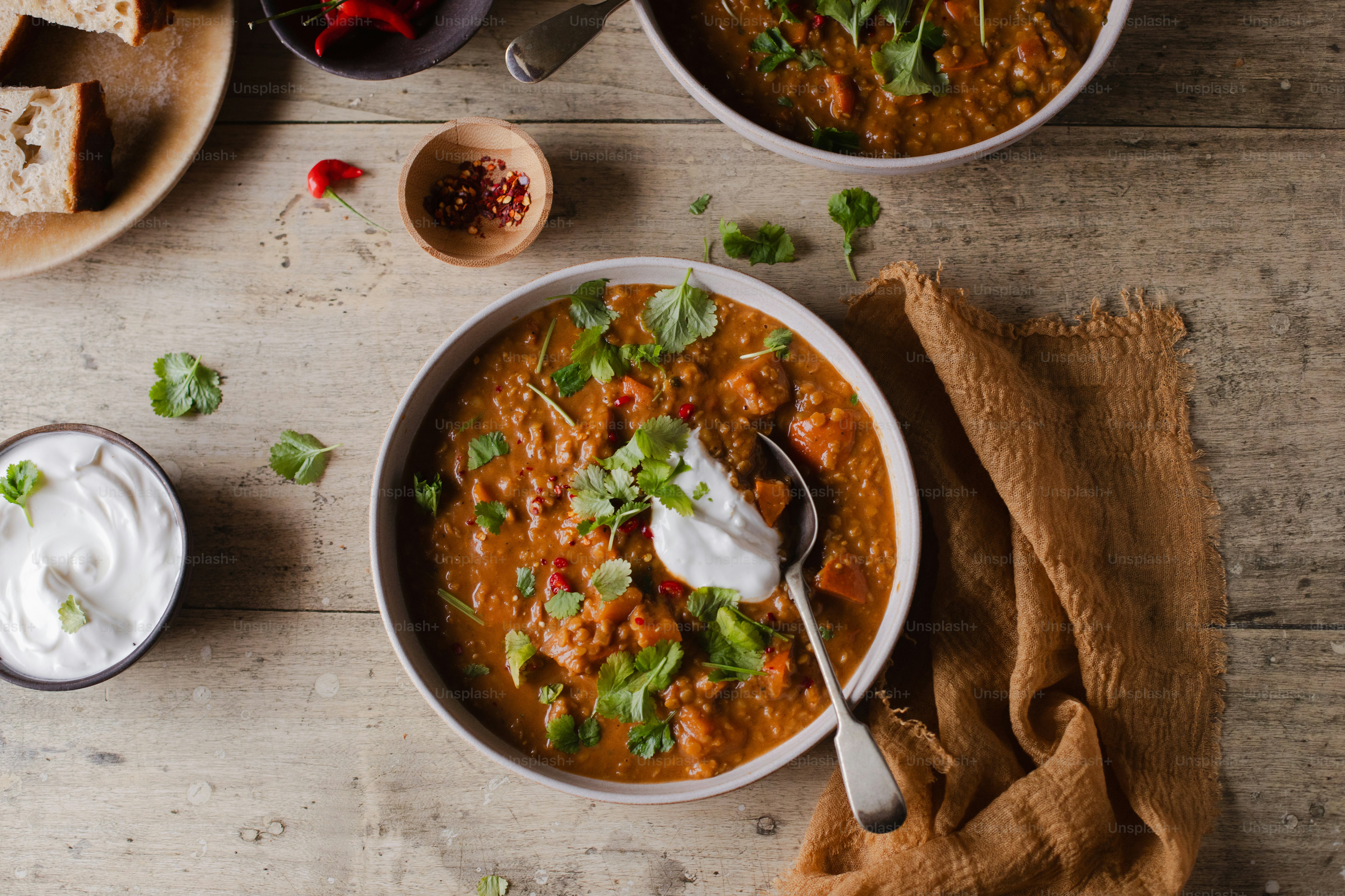 Two bowls of chili with sour cream and bread photo – Food Image on Unsplash