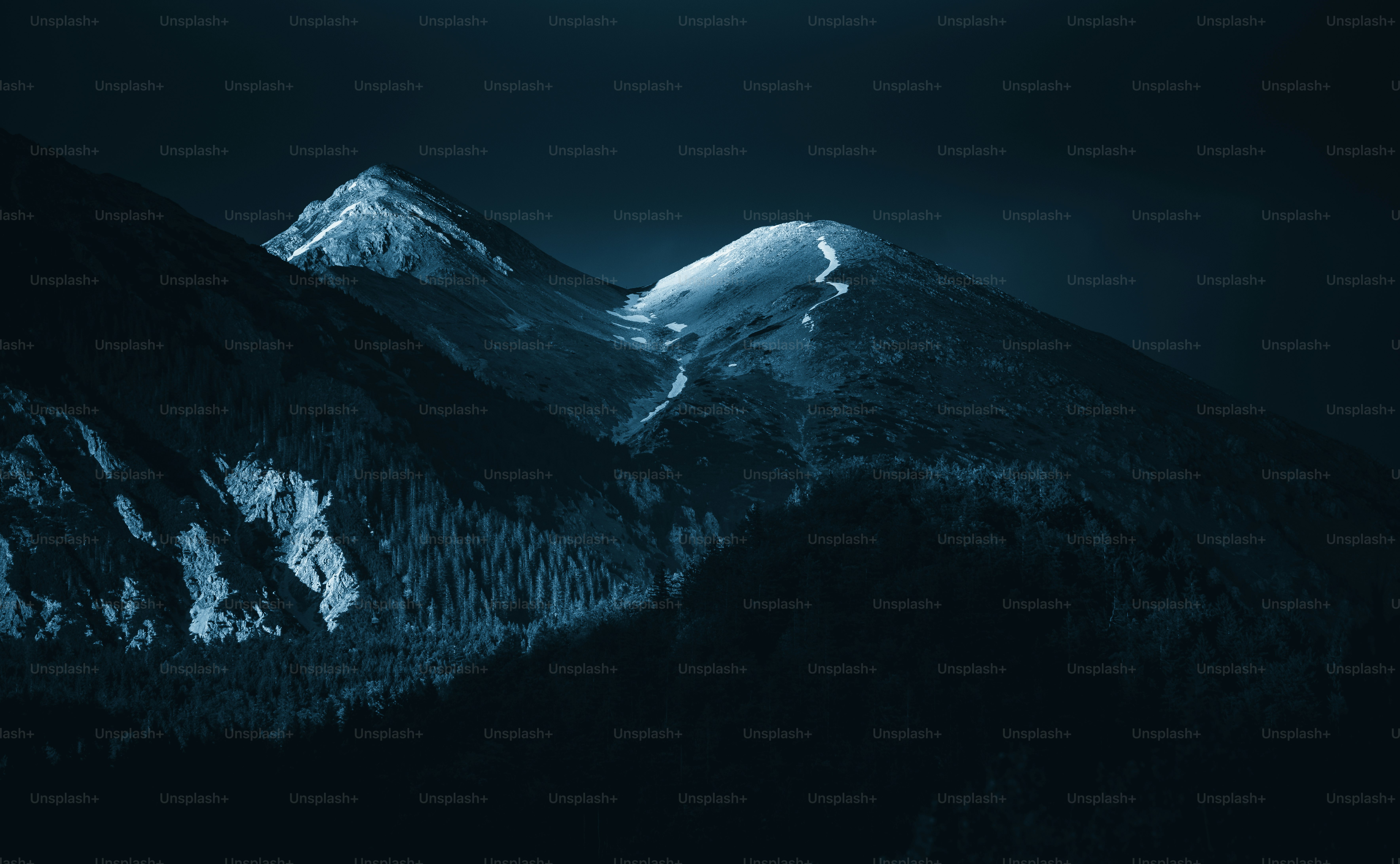 A snow covered field with trees and mountains in the background photo ...