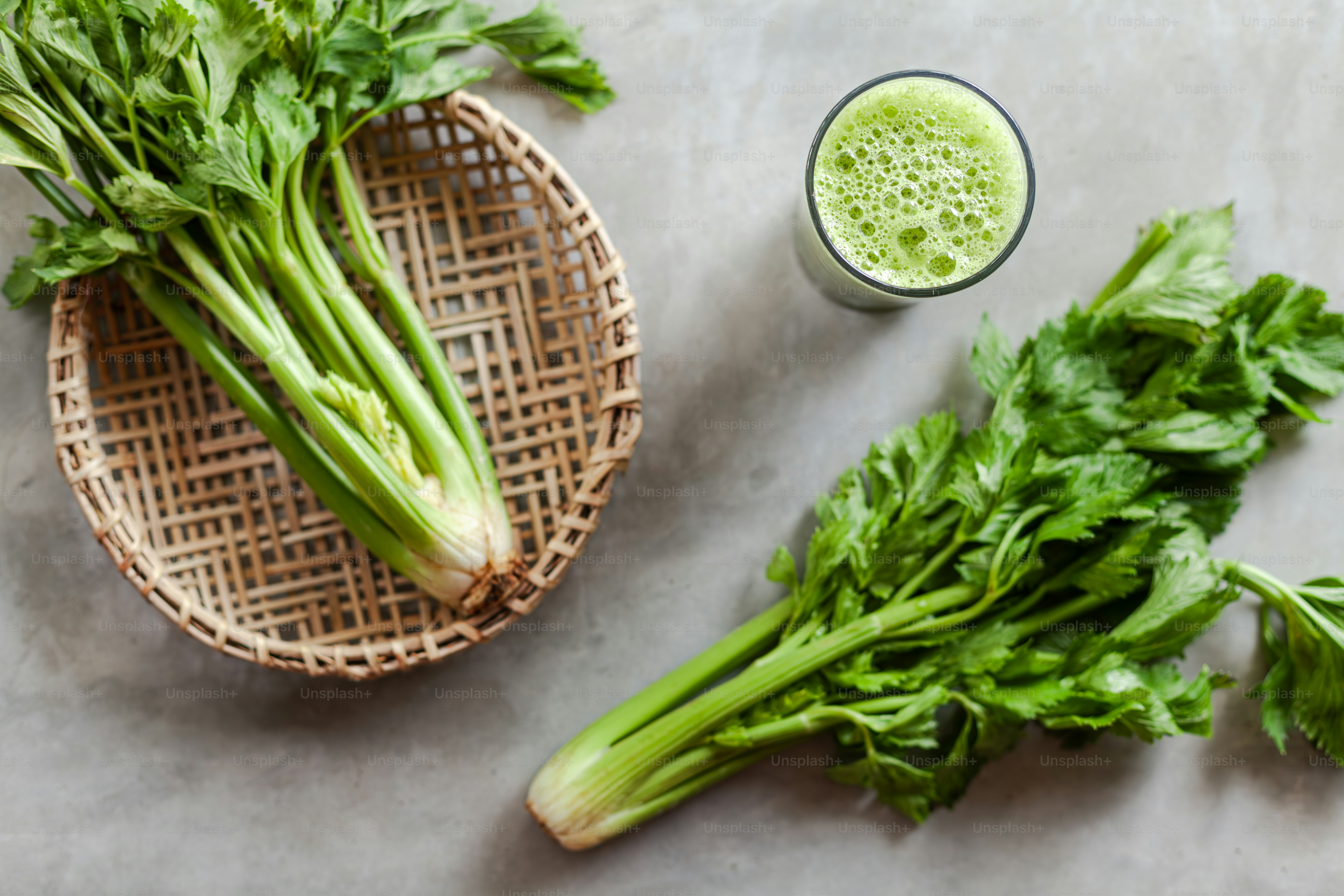 A bunch of celery next to a glass of green juice photo – Food ...
