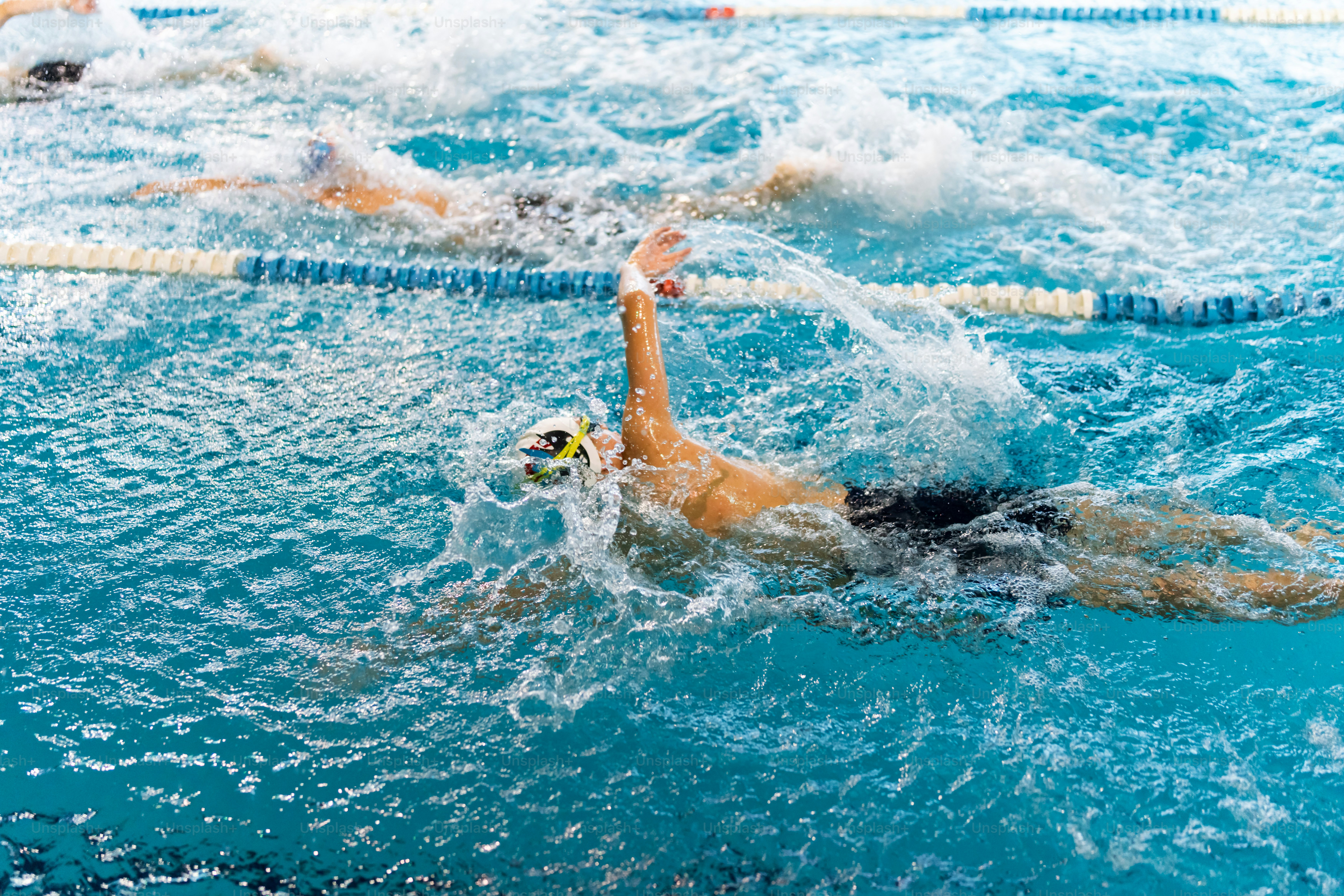 A group of people swimming in a pool photo – Swimmer Image on Unsplash