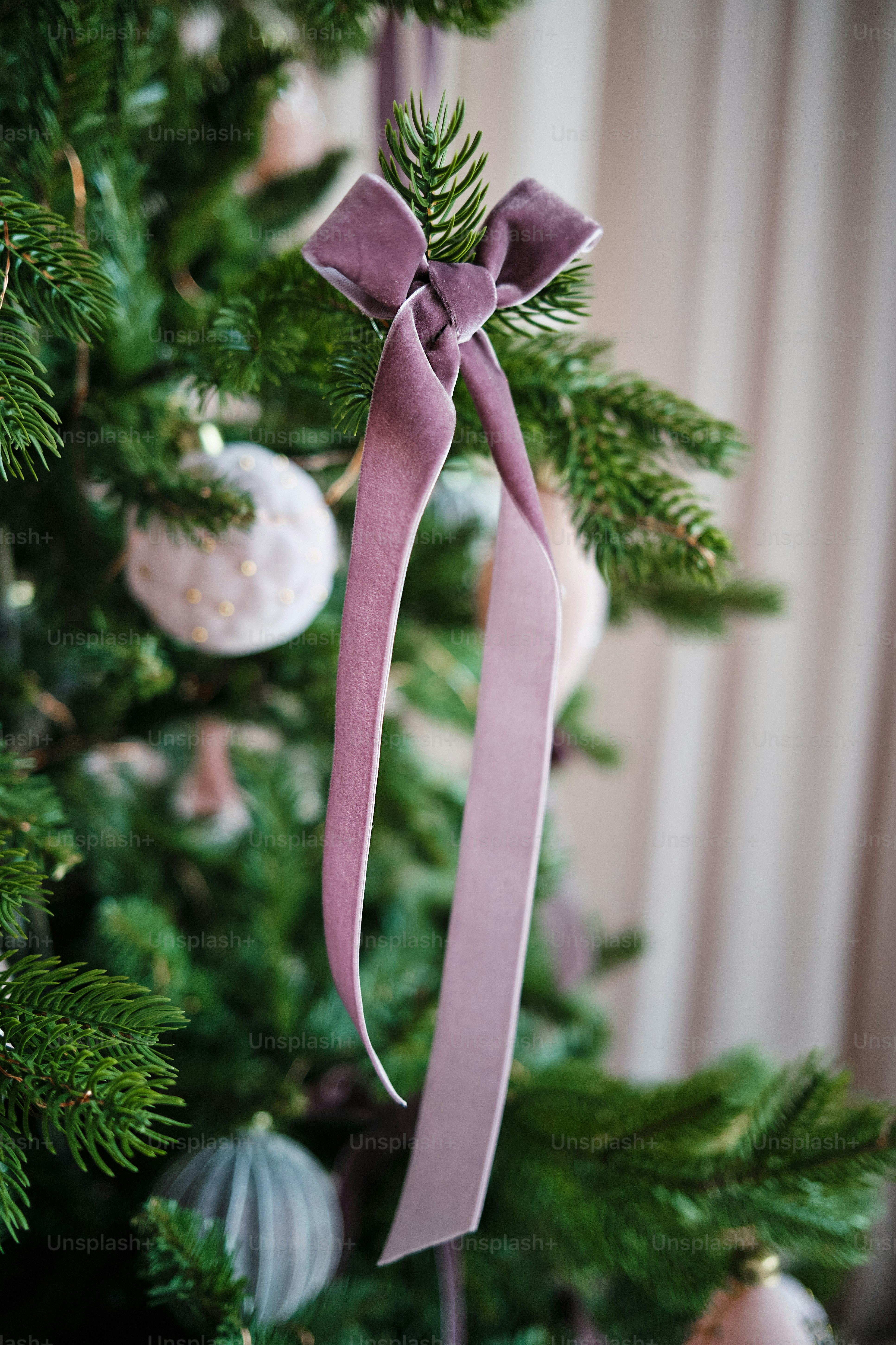 A decorated christmas tree with pink bows in a room photo – Christmas ...