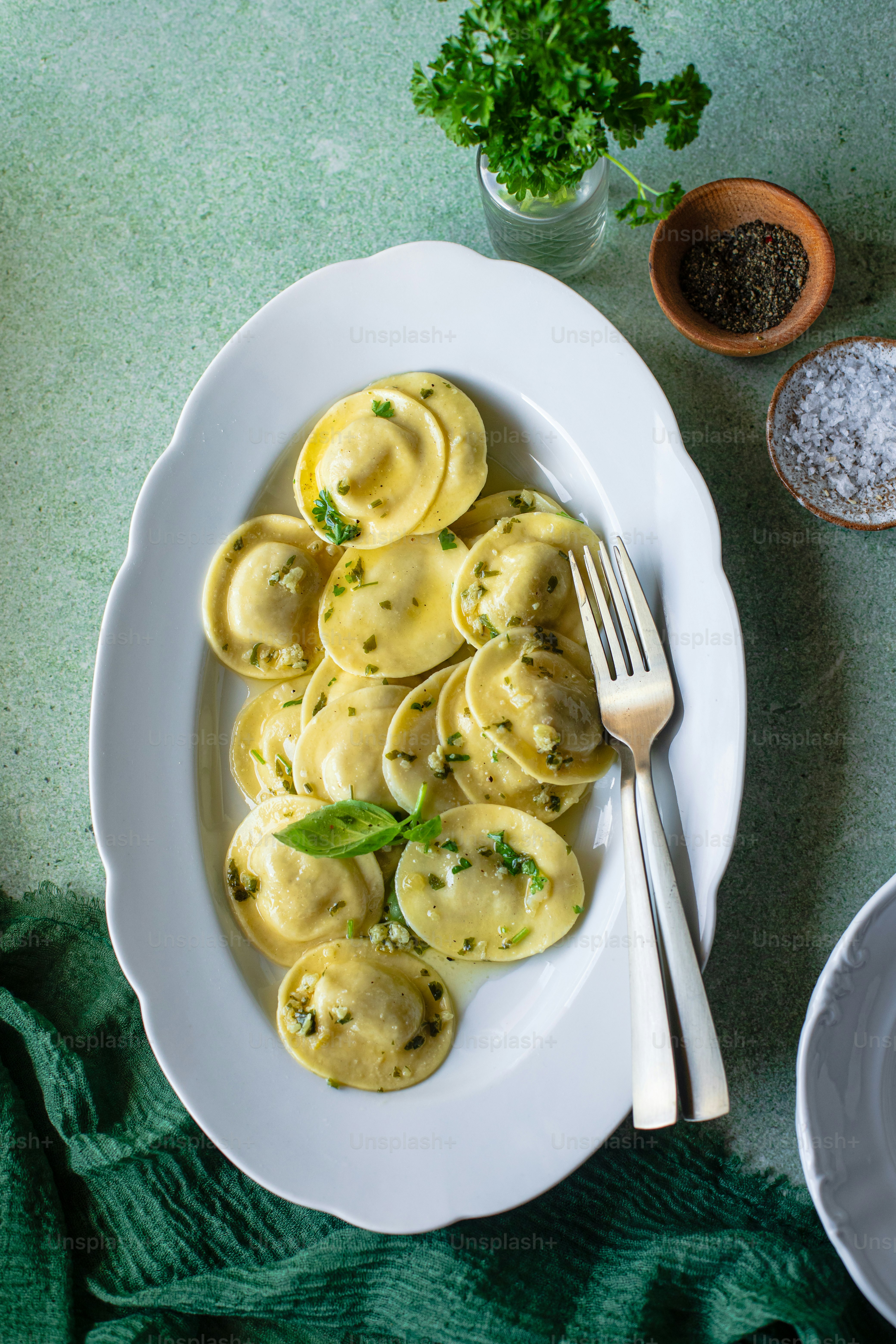 A plate of ravioli with basil and parmesan cheese photo – Culinary ...