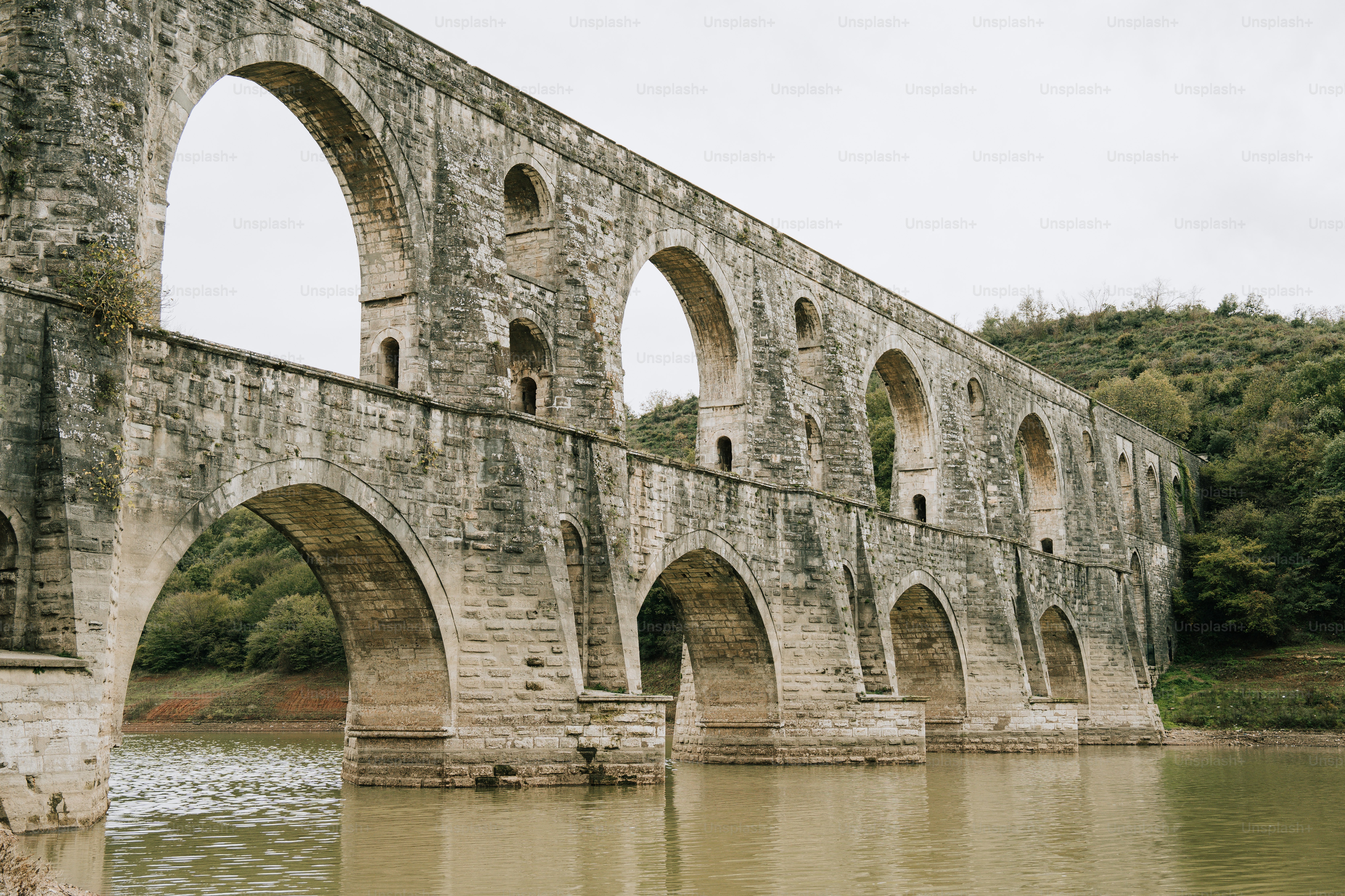 A large stone bridge over a body of water photo – Outdoors Image on ...