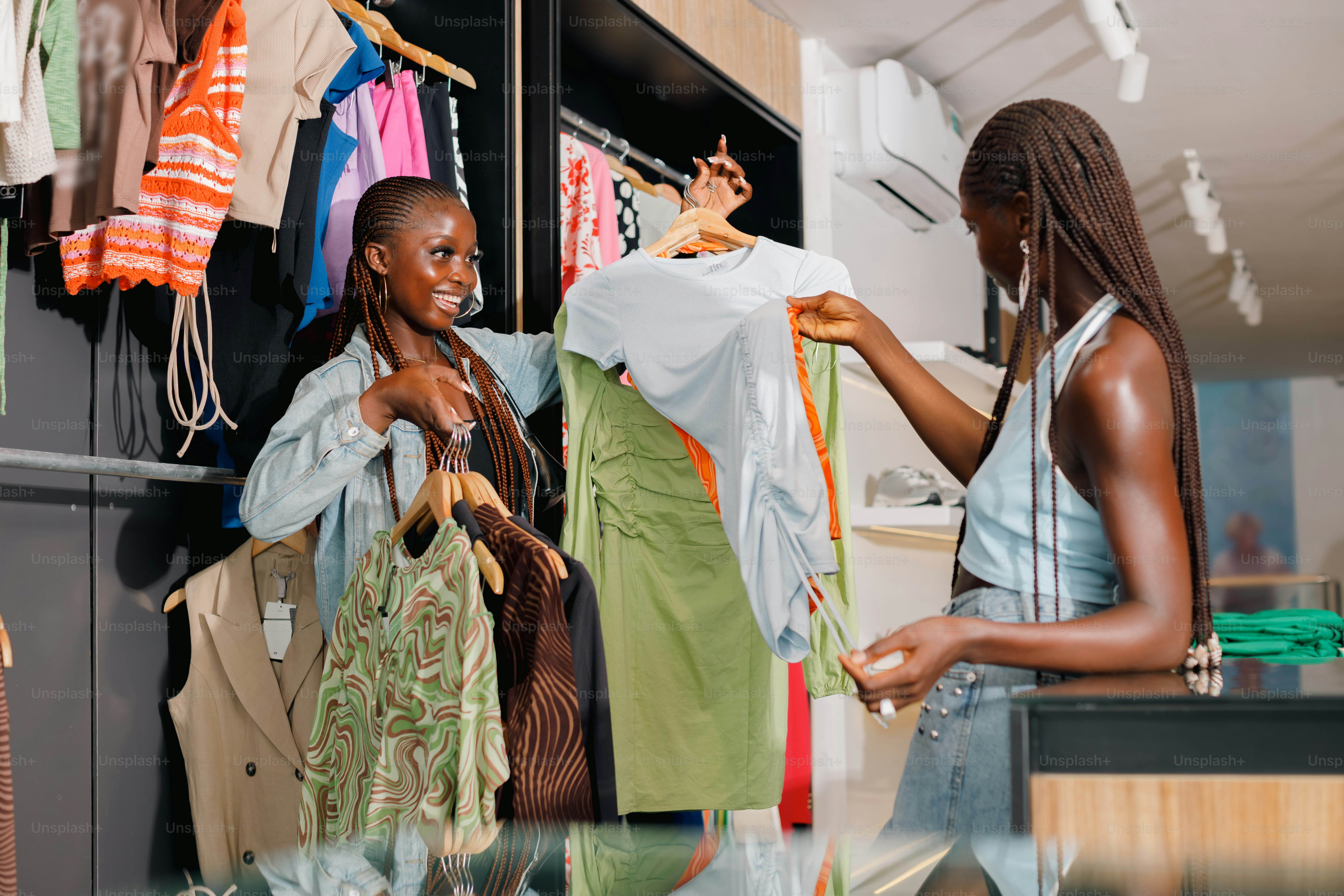 Two women looking at clothes in a clothing store photo – Black friday ...