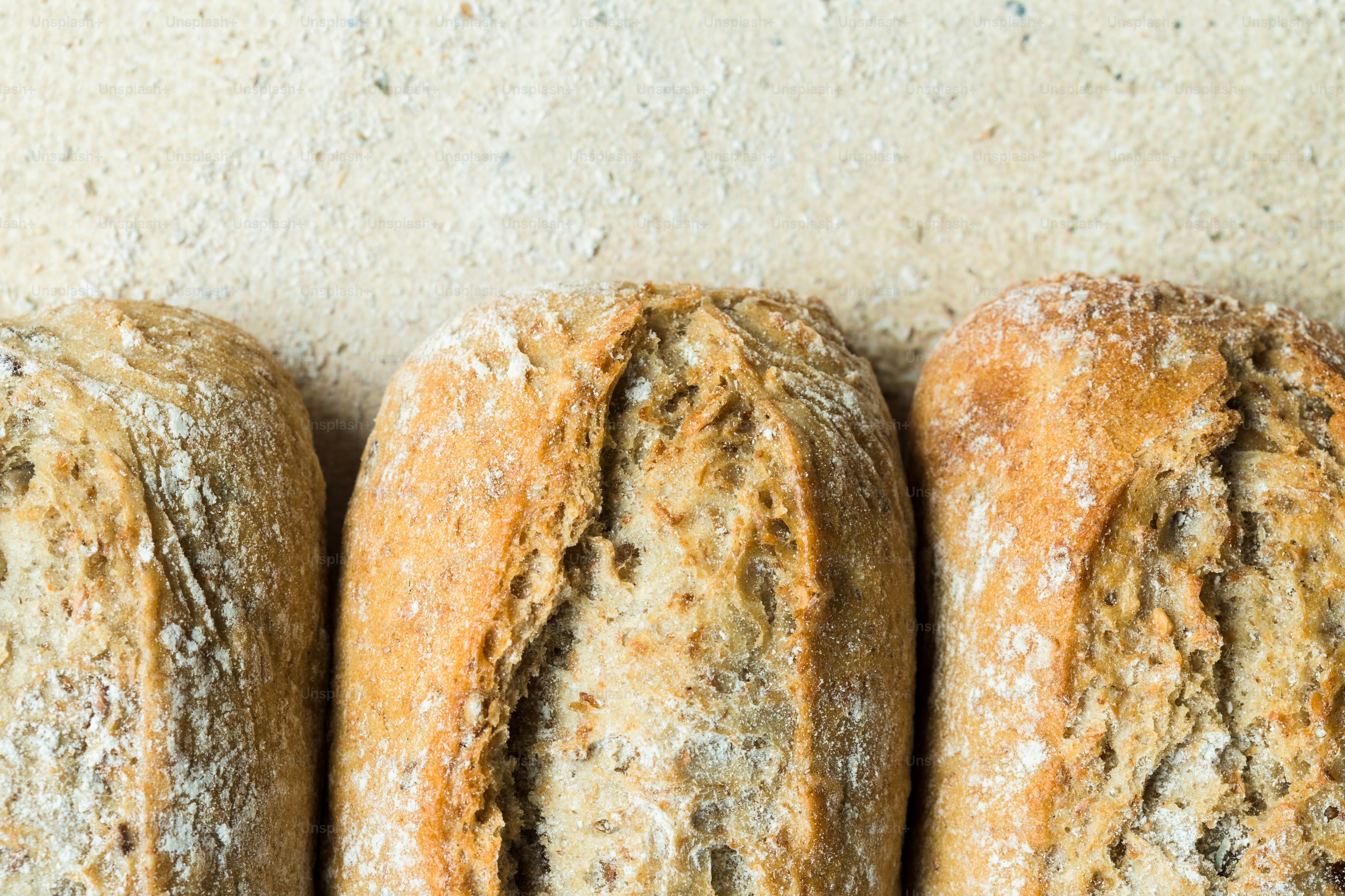 Four loaves of bread lined up on a counter photo – Sourdough Image on ...