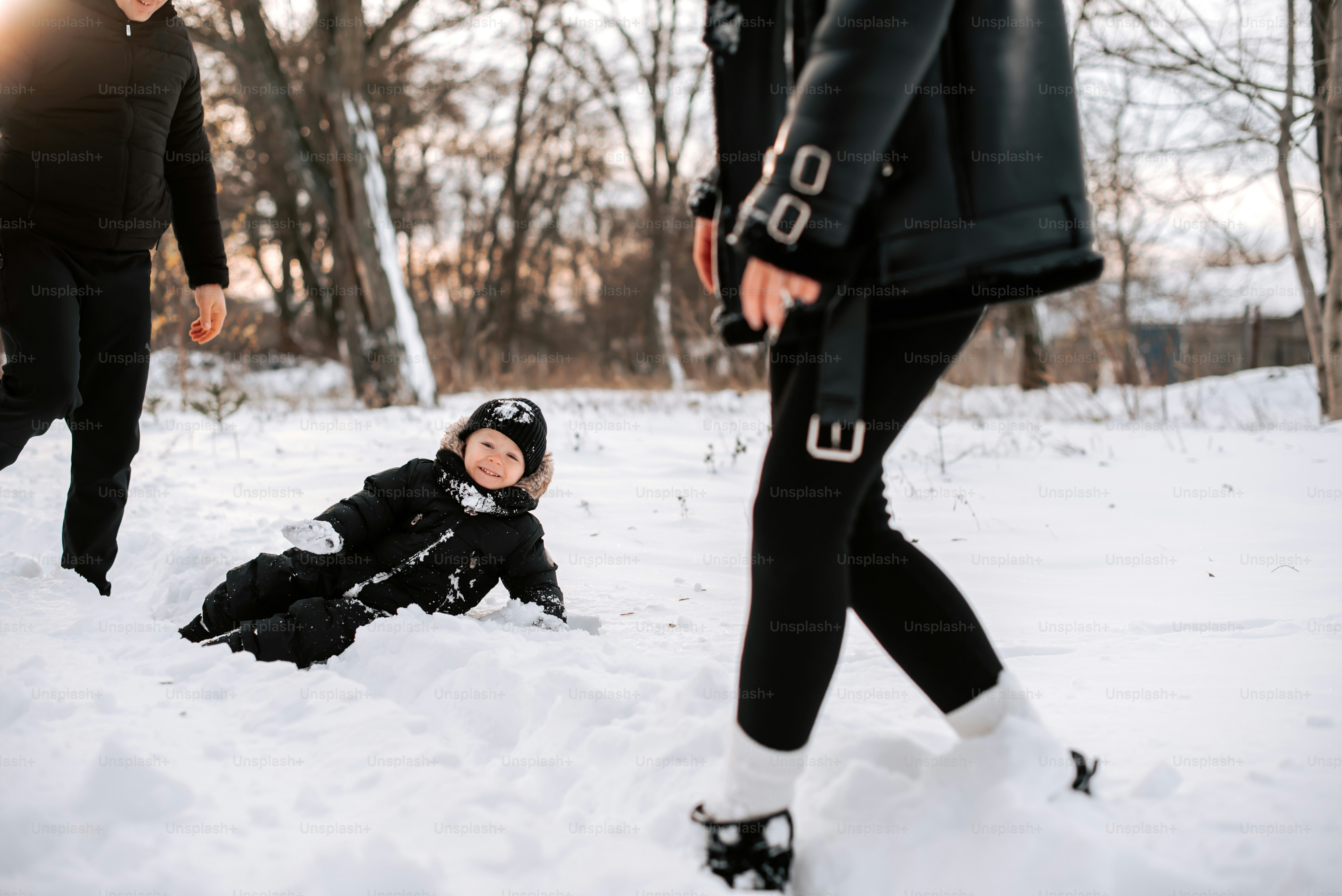 Foto Un niño pequeño está tumbado en la nieve – Día de nieve Imagen en ...