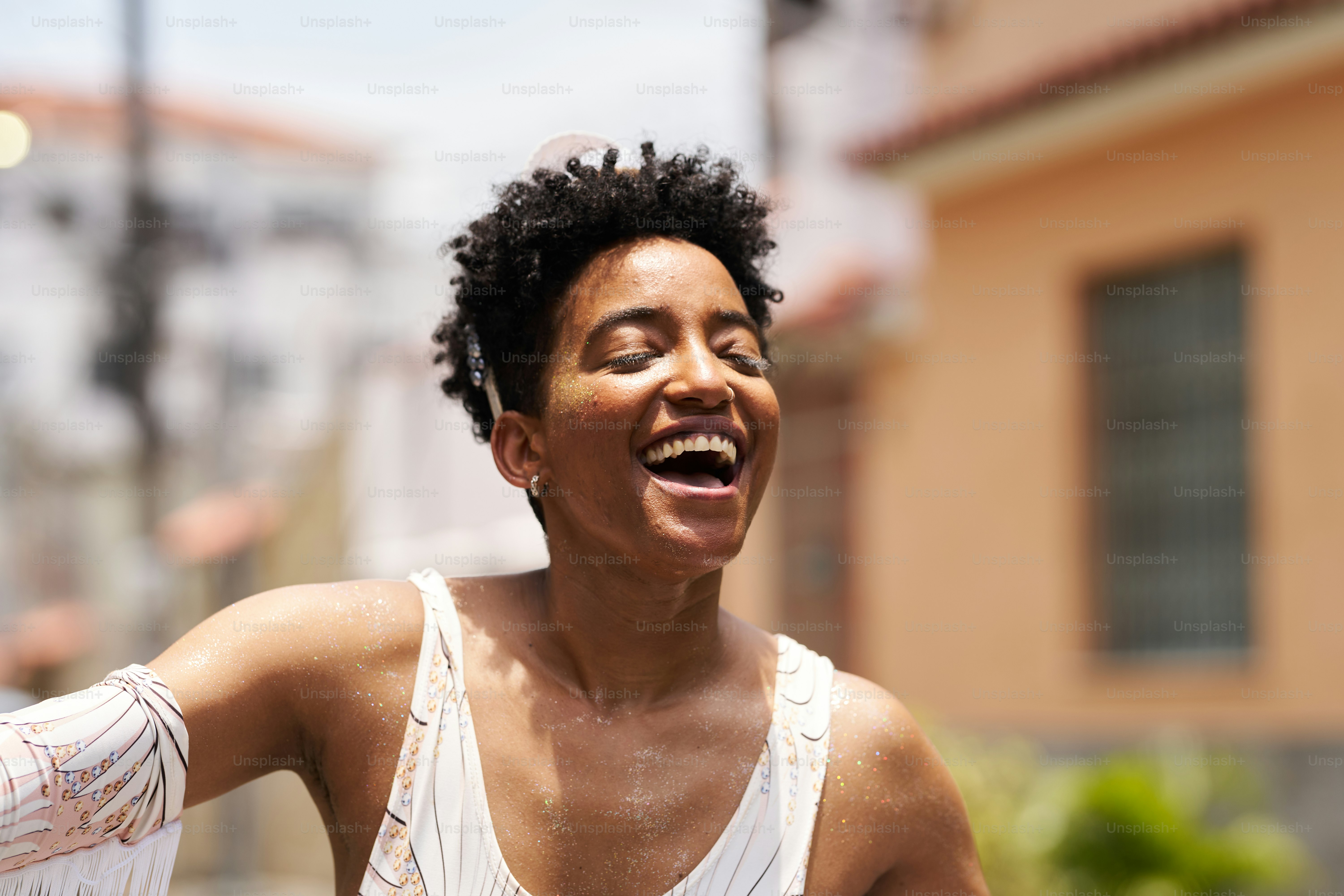 A woman laughing while standing in front of a building photo – Black ...