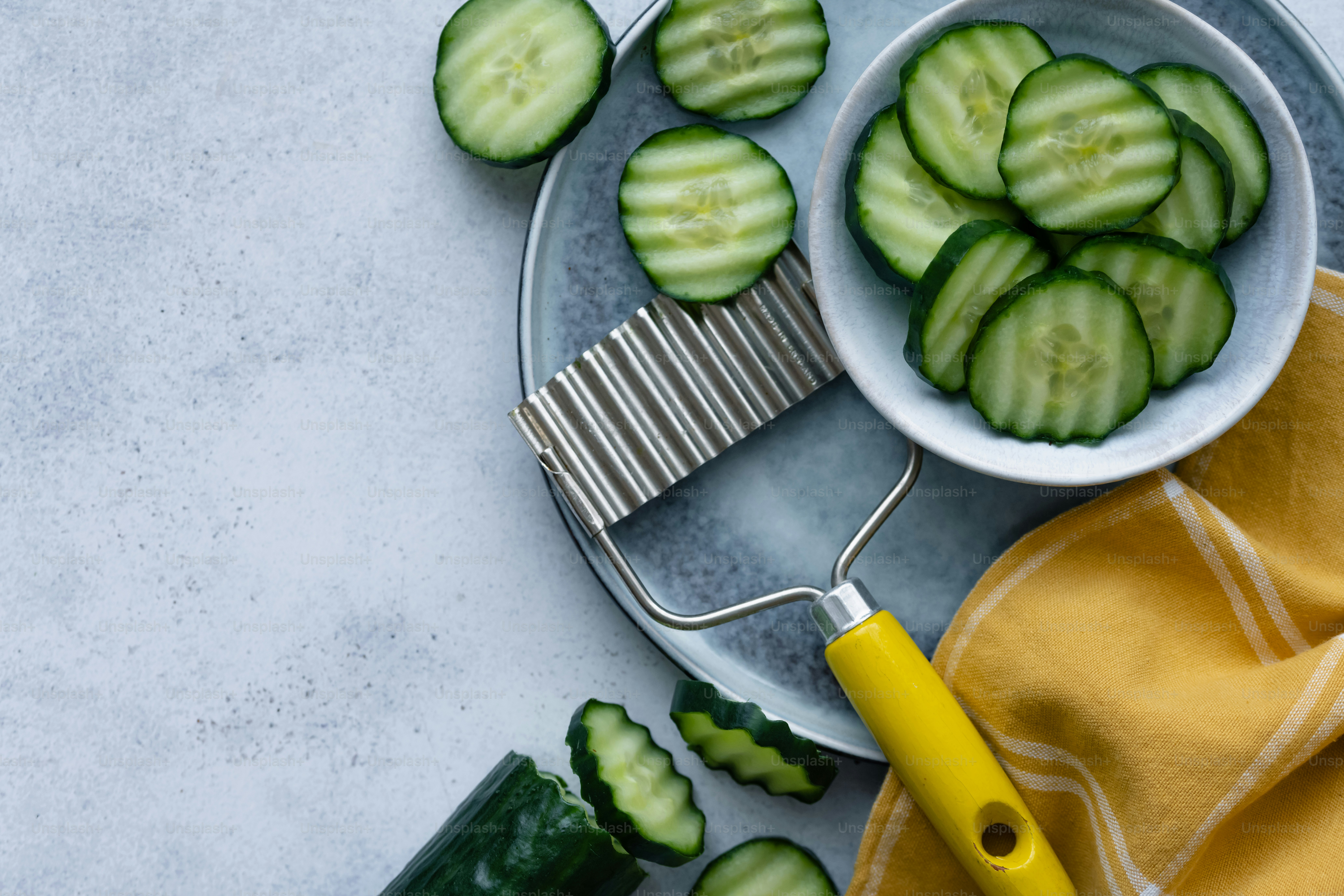 A plate of sliced cucumbers and a bowl of sliced cucumbers photo ...