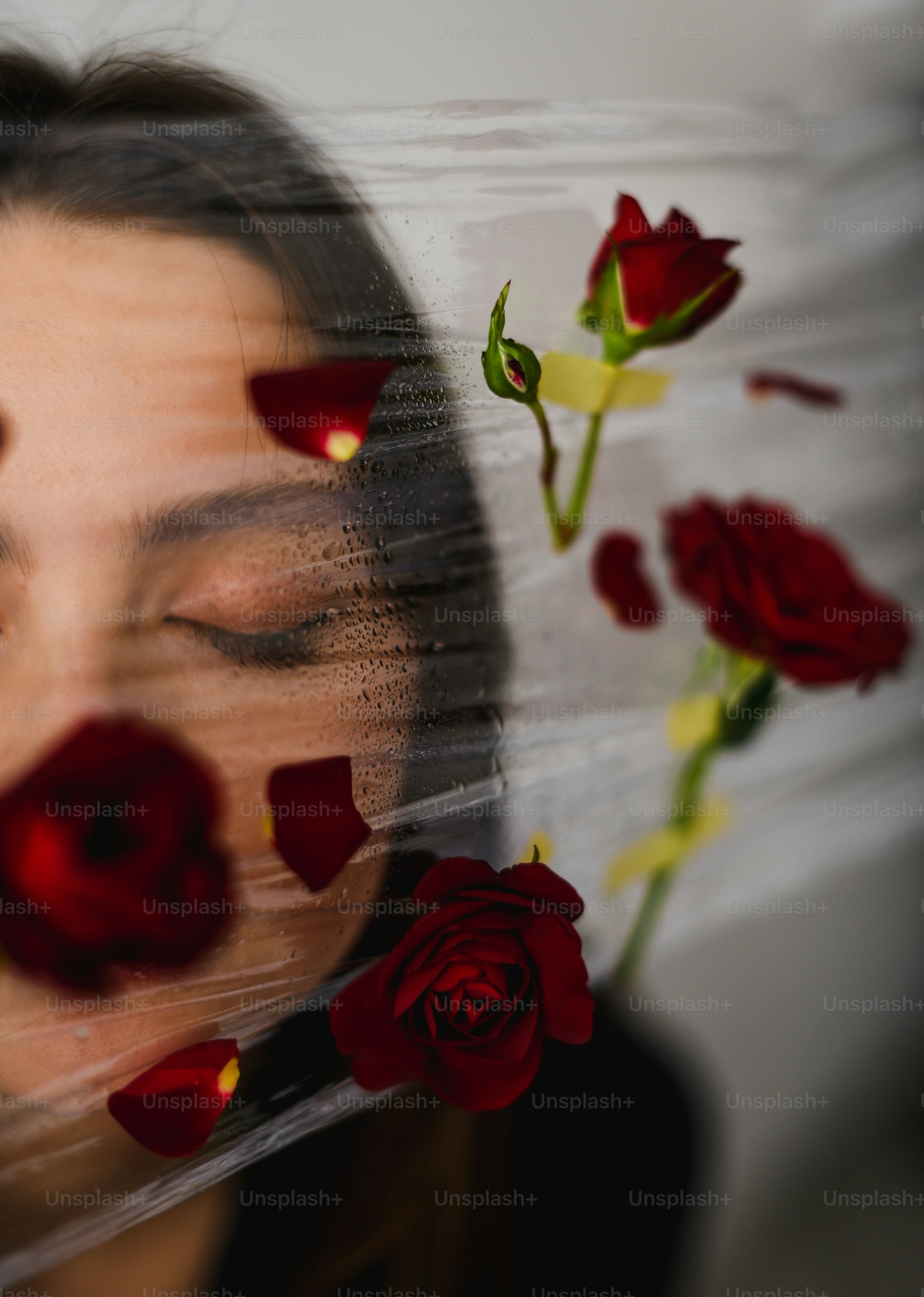 A woman with her eyes closed and roses in front of her face photo – Red ...